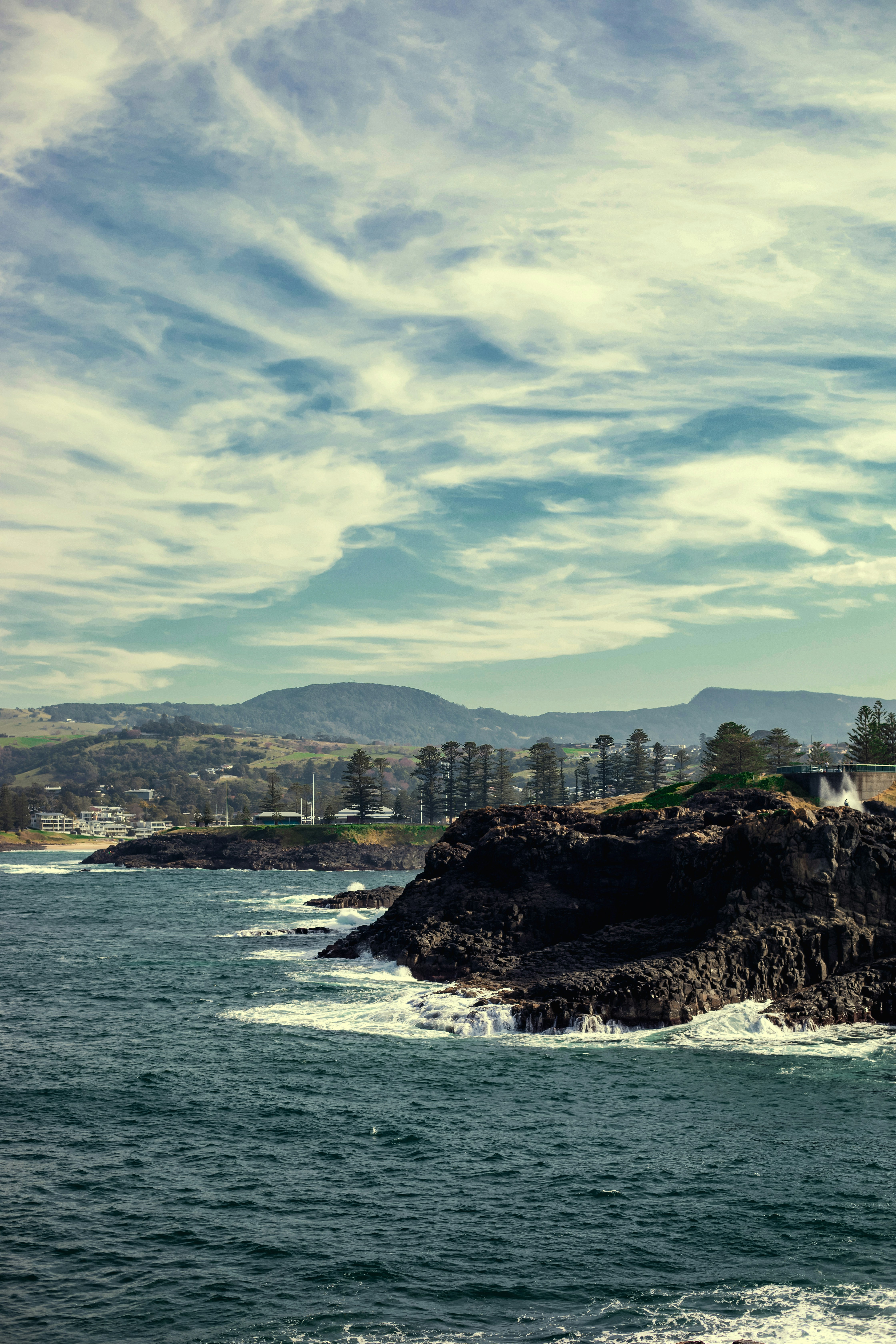 Rocky Promontory Meets the Pacific Under a Wisped Sky