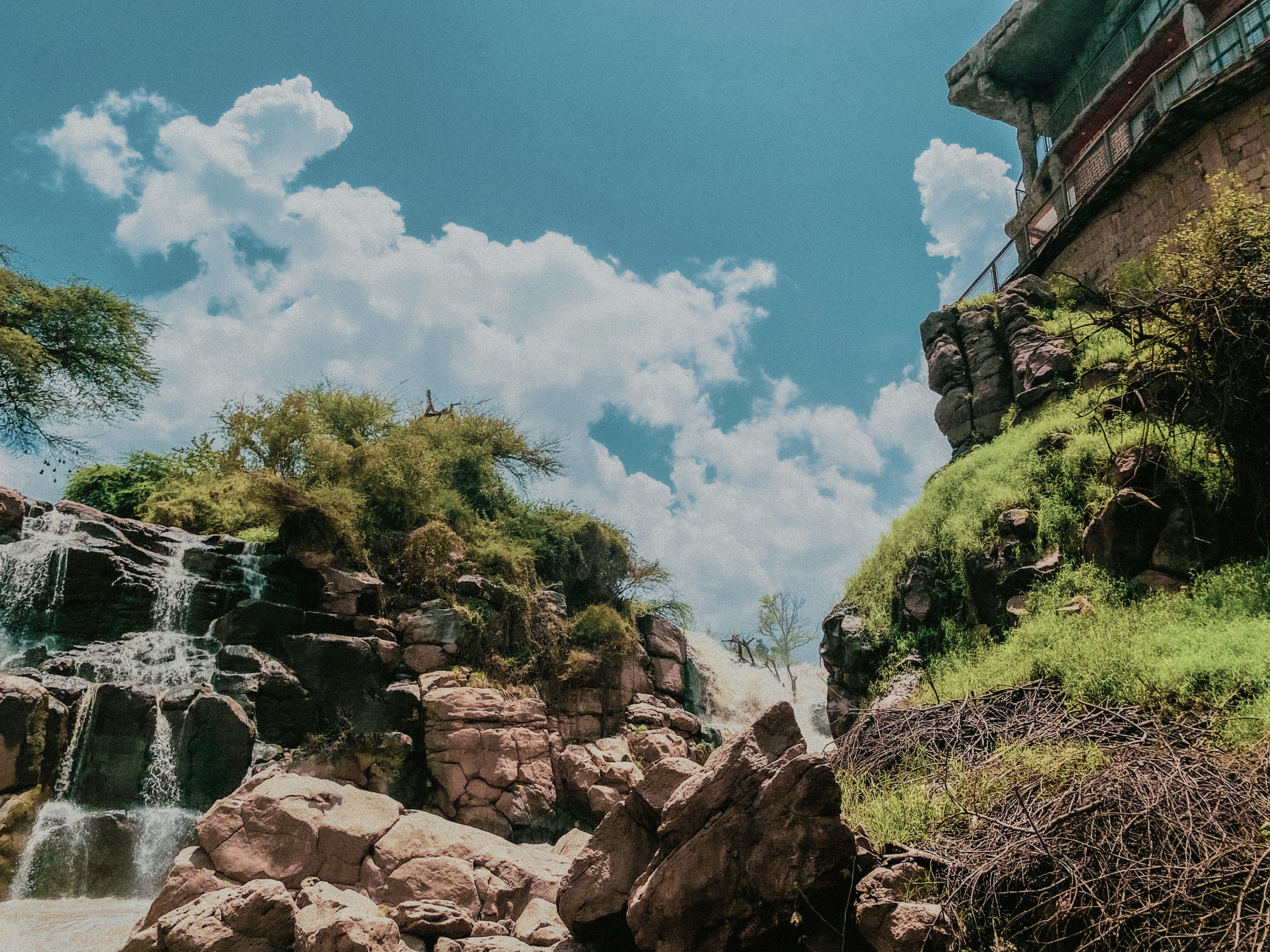 A waterfall with a building on top of it photo – Free Kuriftu resort ...
