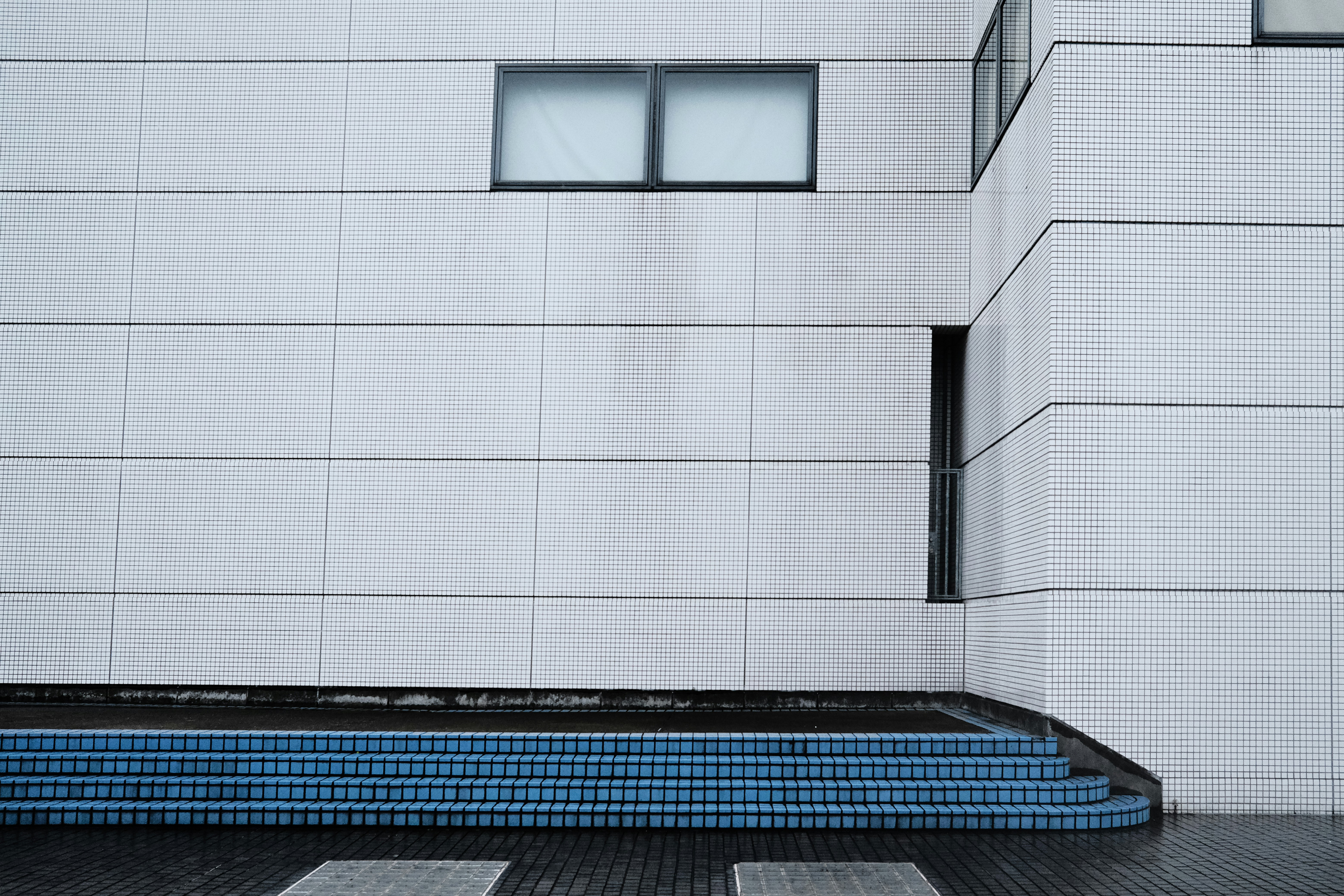 Blue Steps Framing a Quiet White Facade: A Minimalist Architectural Moment