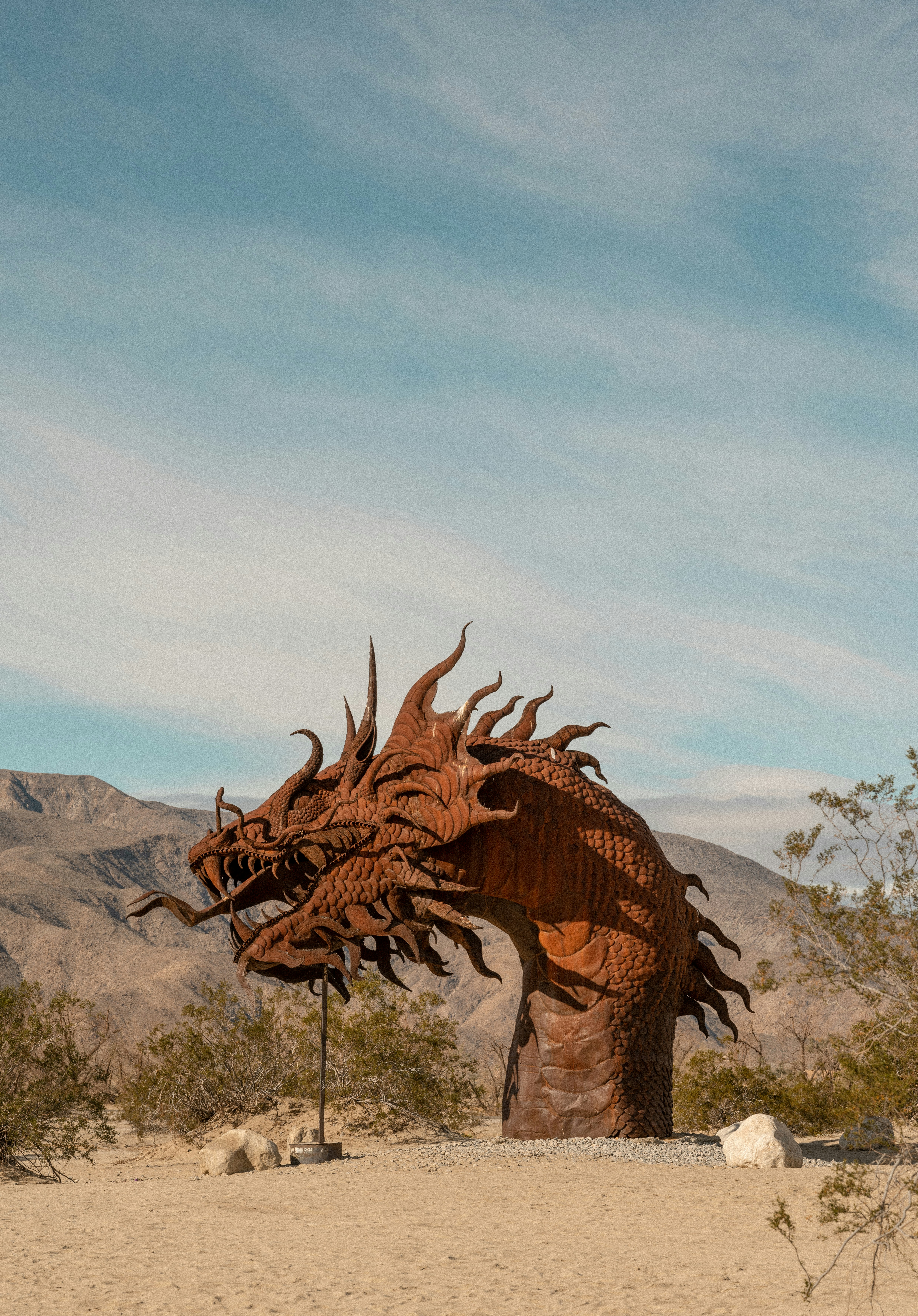 A statue of a dragon in the middle of a desert photo – Free Desert ...