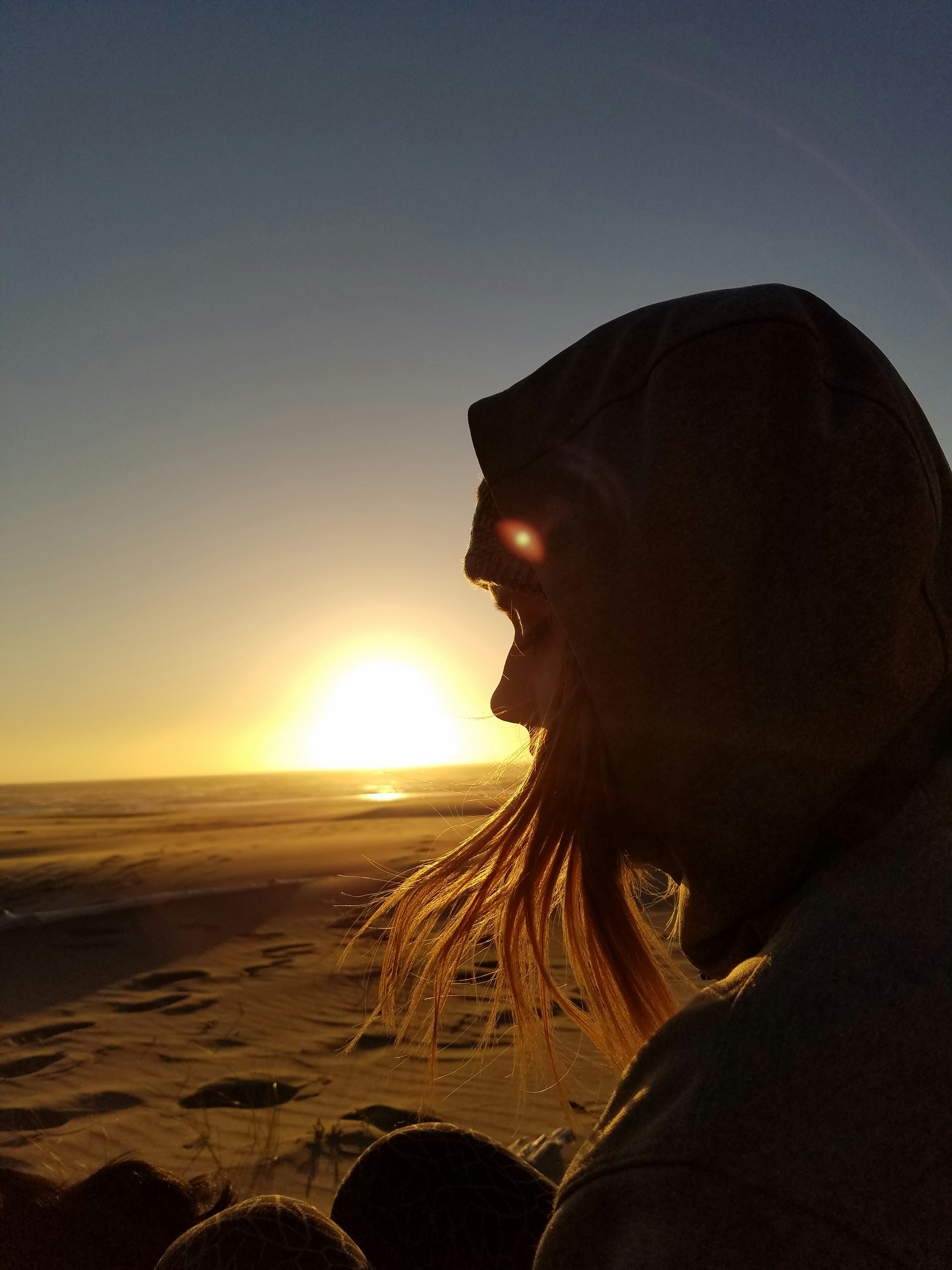 Horizon Glow: Hoodie Silhouette at the Seashore
