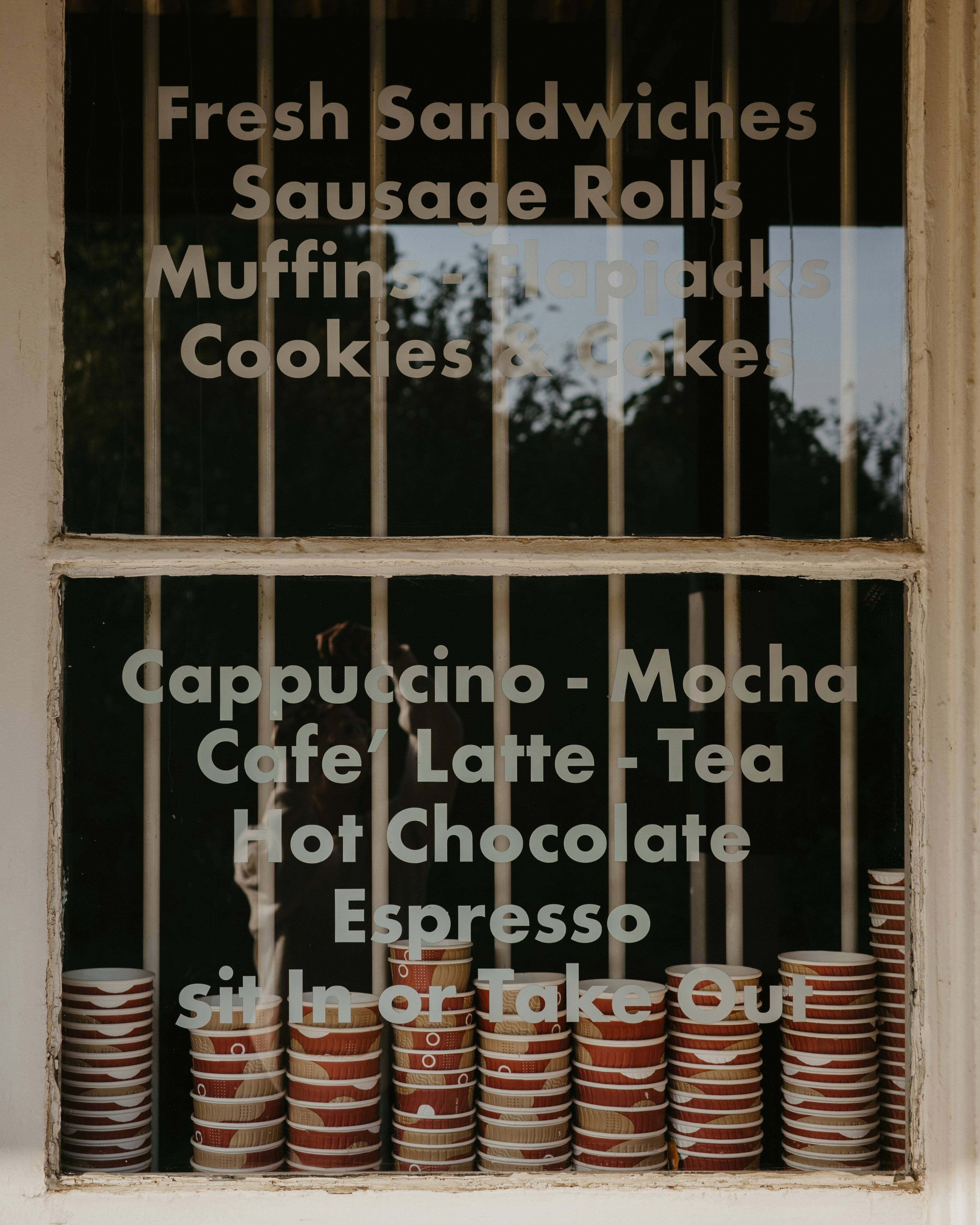 Cups Behind Grille: A Quiet Café Window Display