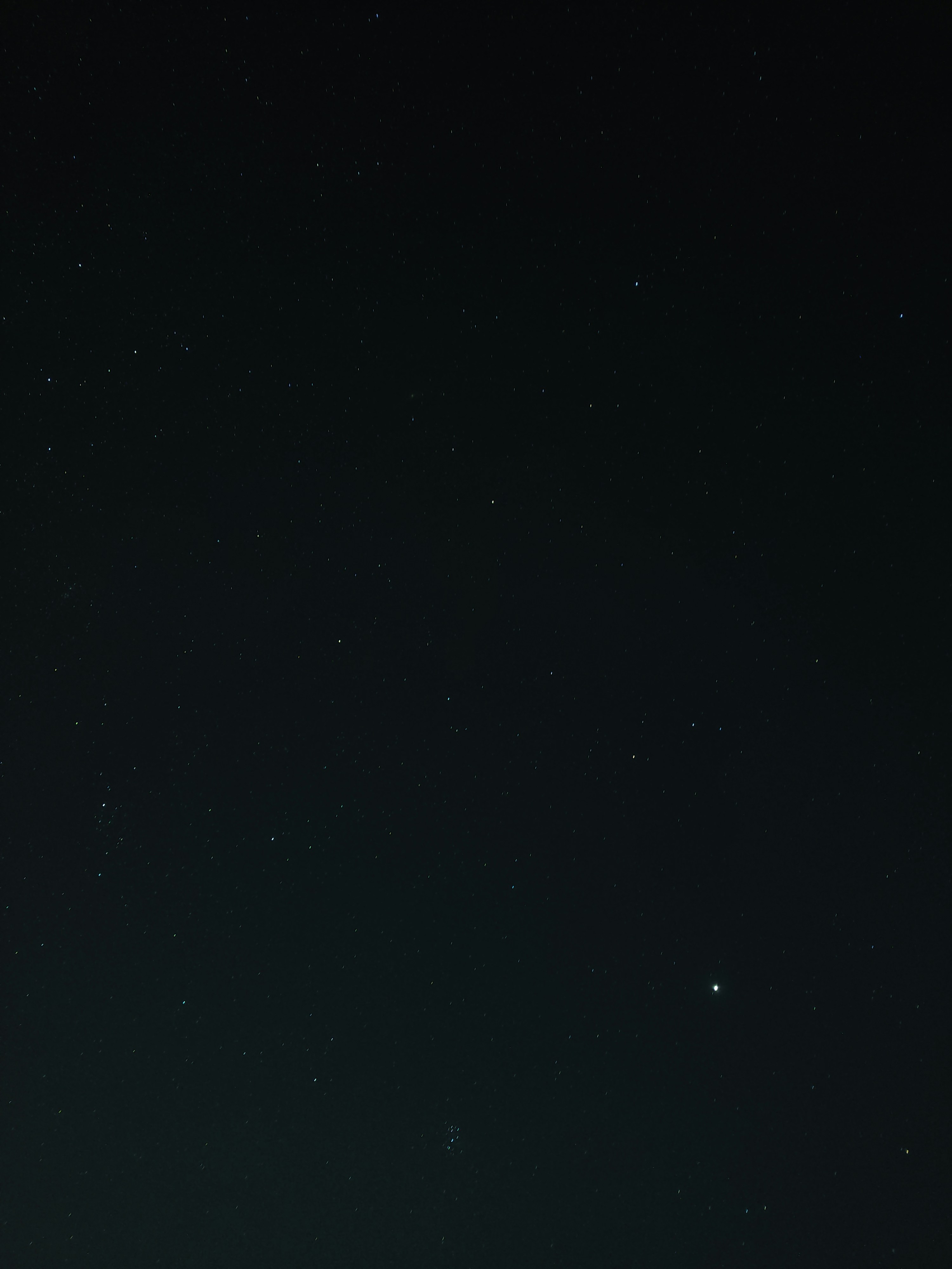 a dark sky with stars and a few clouds