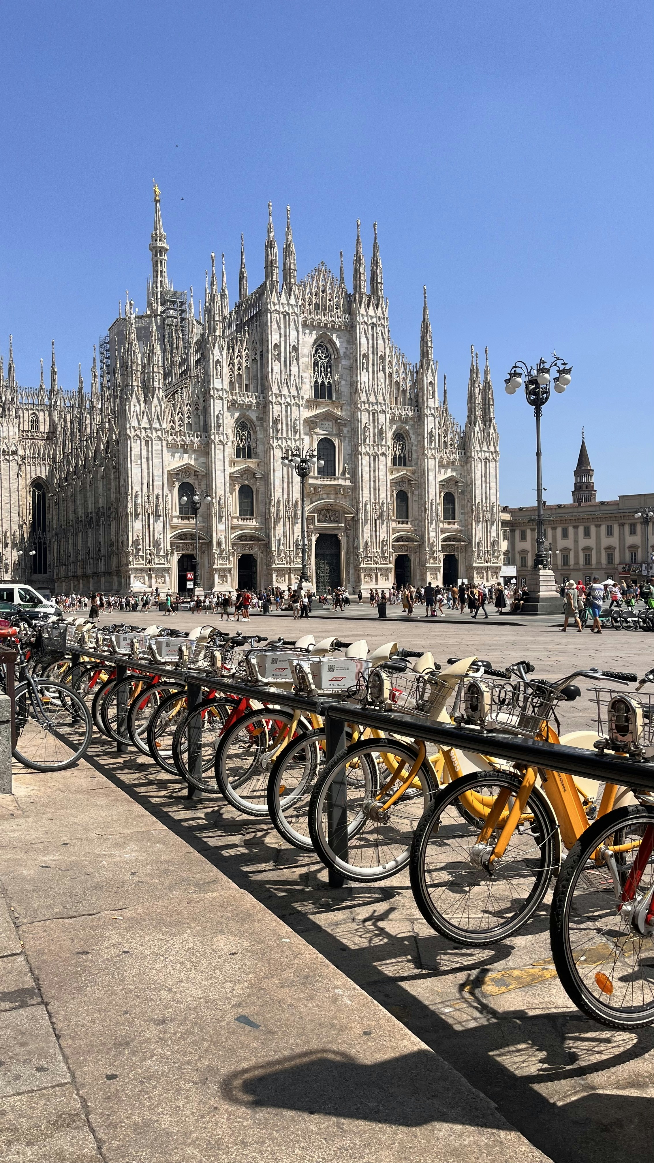 Line of Bicycles, Cathedral Spires: Milan's Duomo Under a Crisp Blue Sky