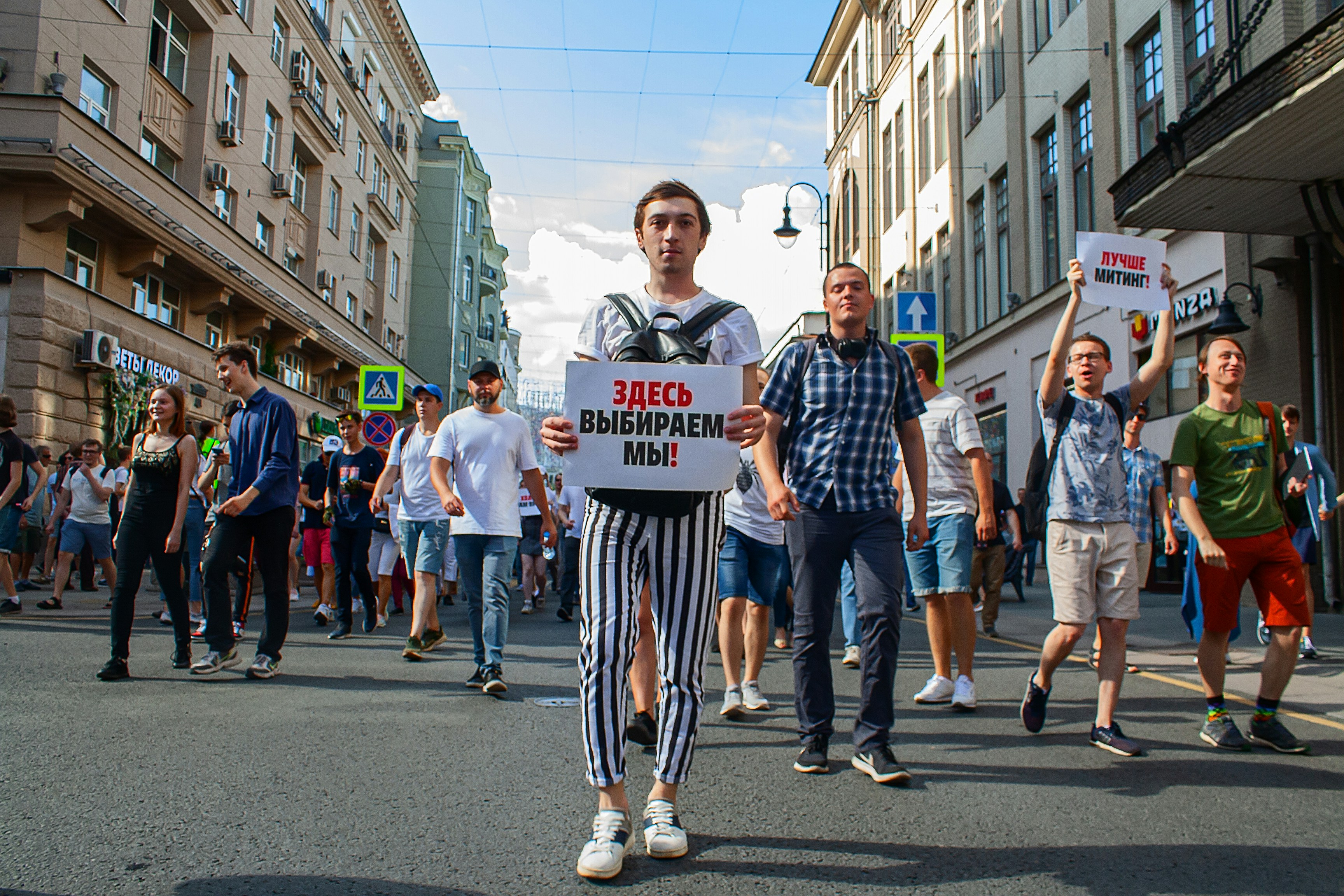 Un homme tenant une pancarte au milieu d’une rue photo – Photo ...