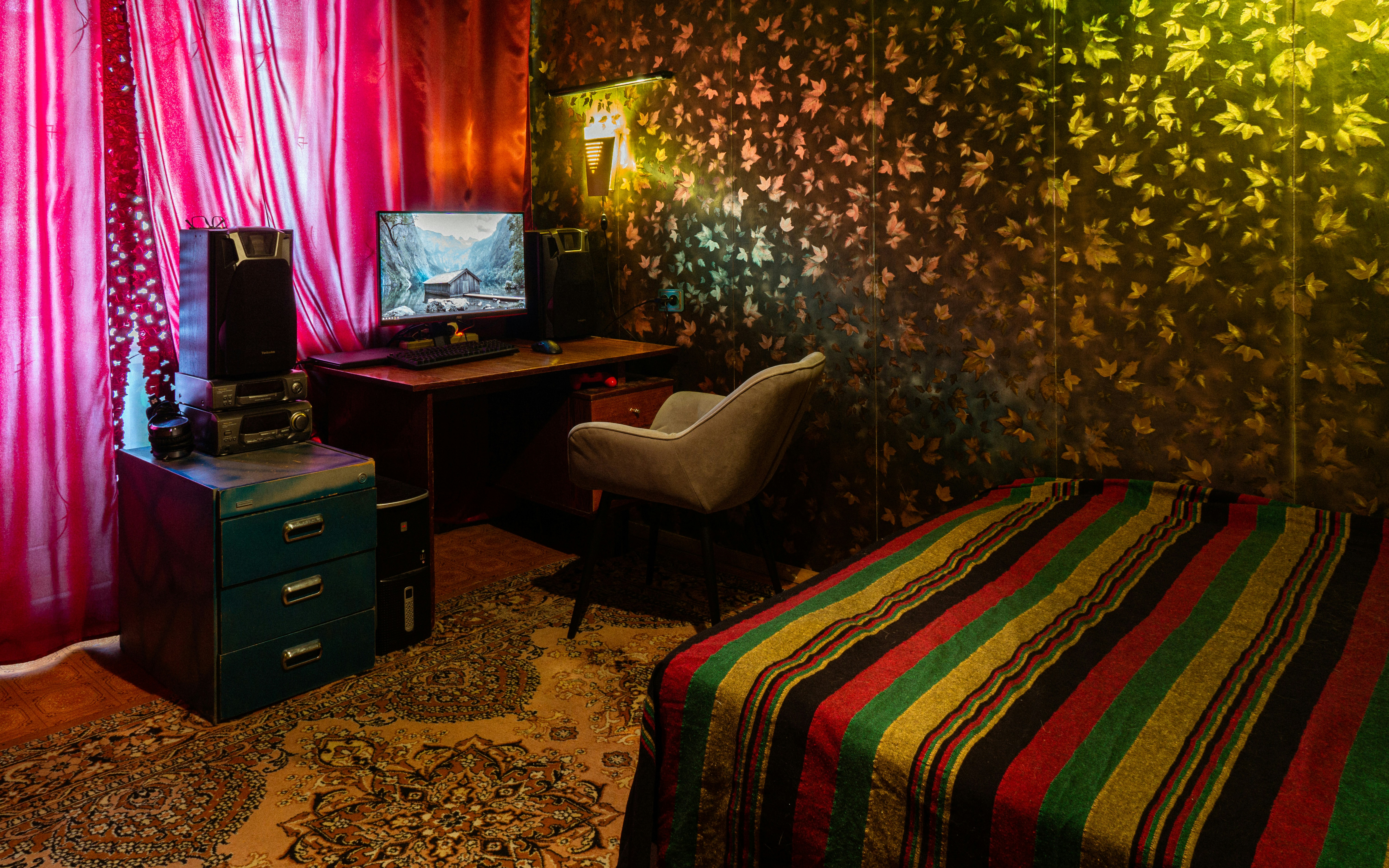 Neon Deskscape: A Dim Bedroom Studio Bathed in Velvet Floral Light