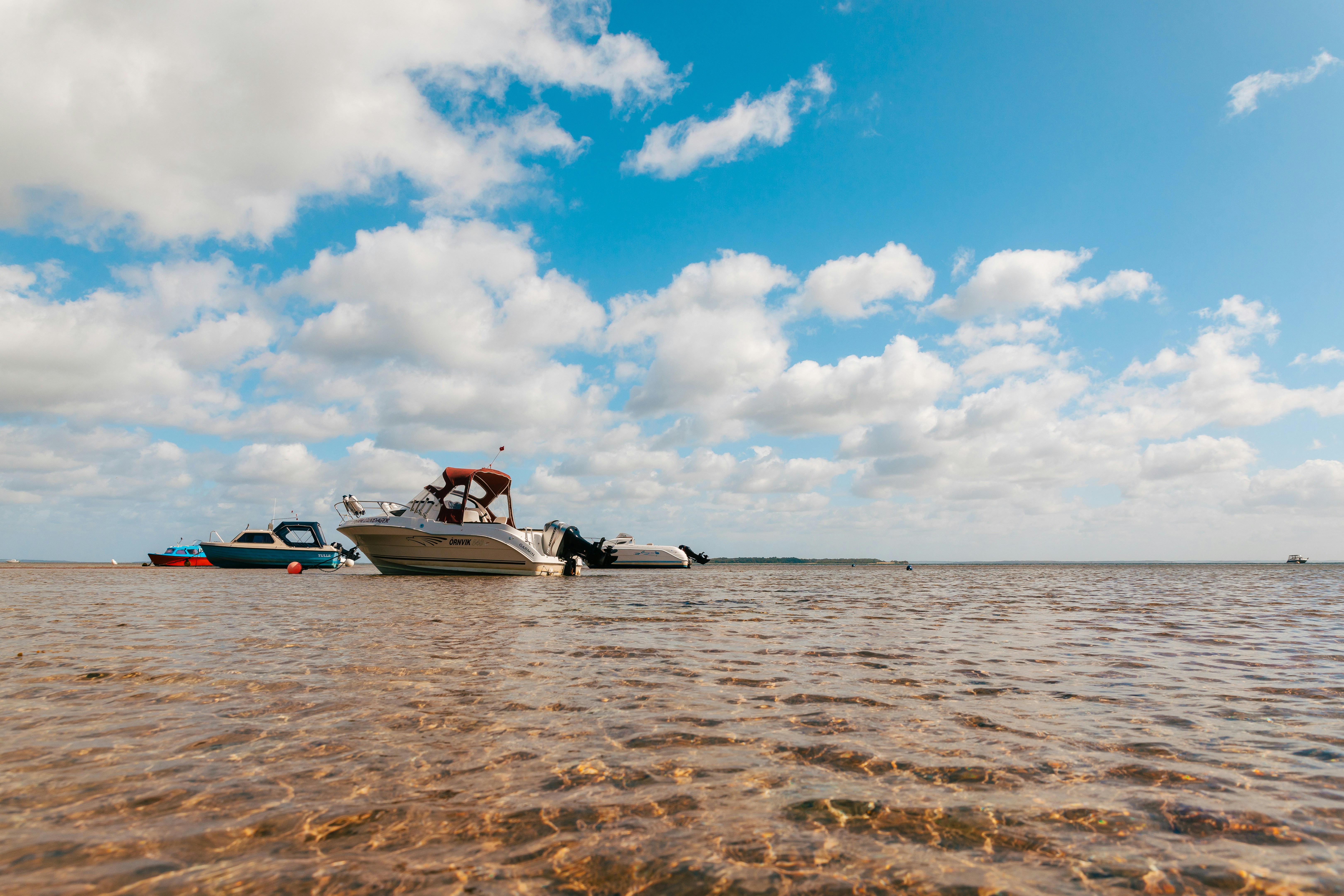 Un par de botes que están sentados en el agua foto – Imagen de Verano ...