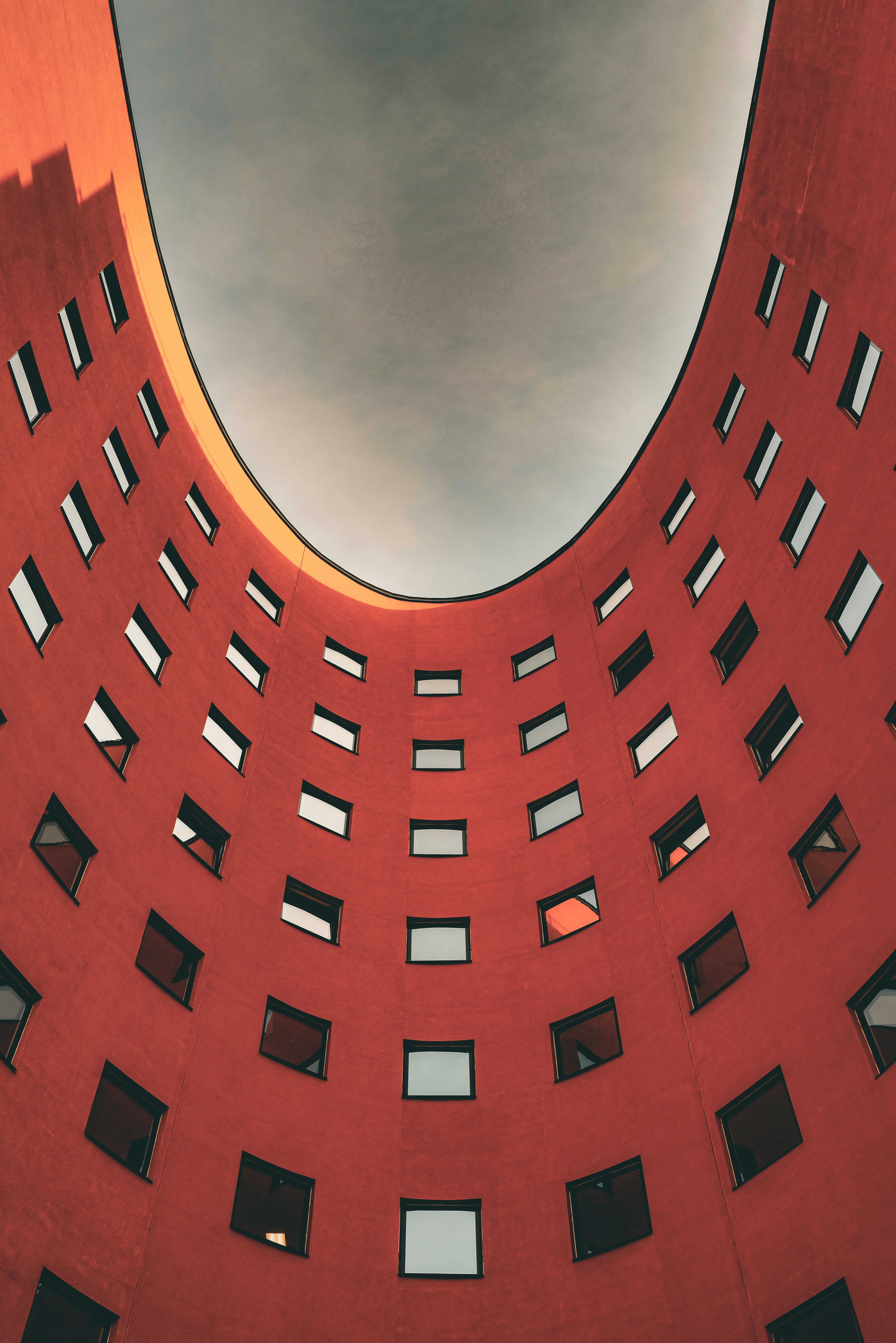 Skyward Curve: Red Circular Atrium Framing an Open Sky