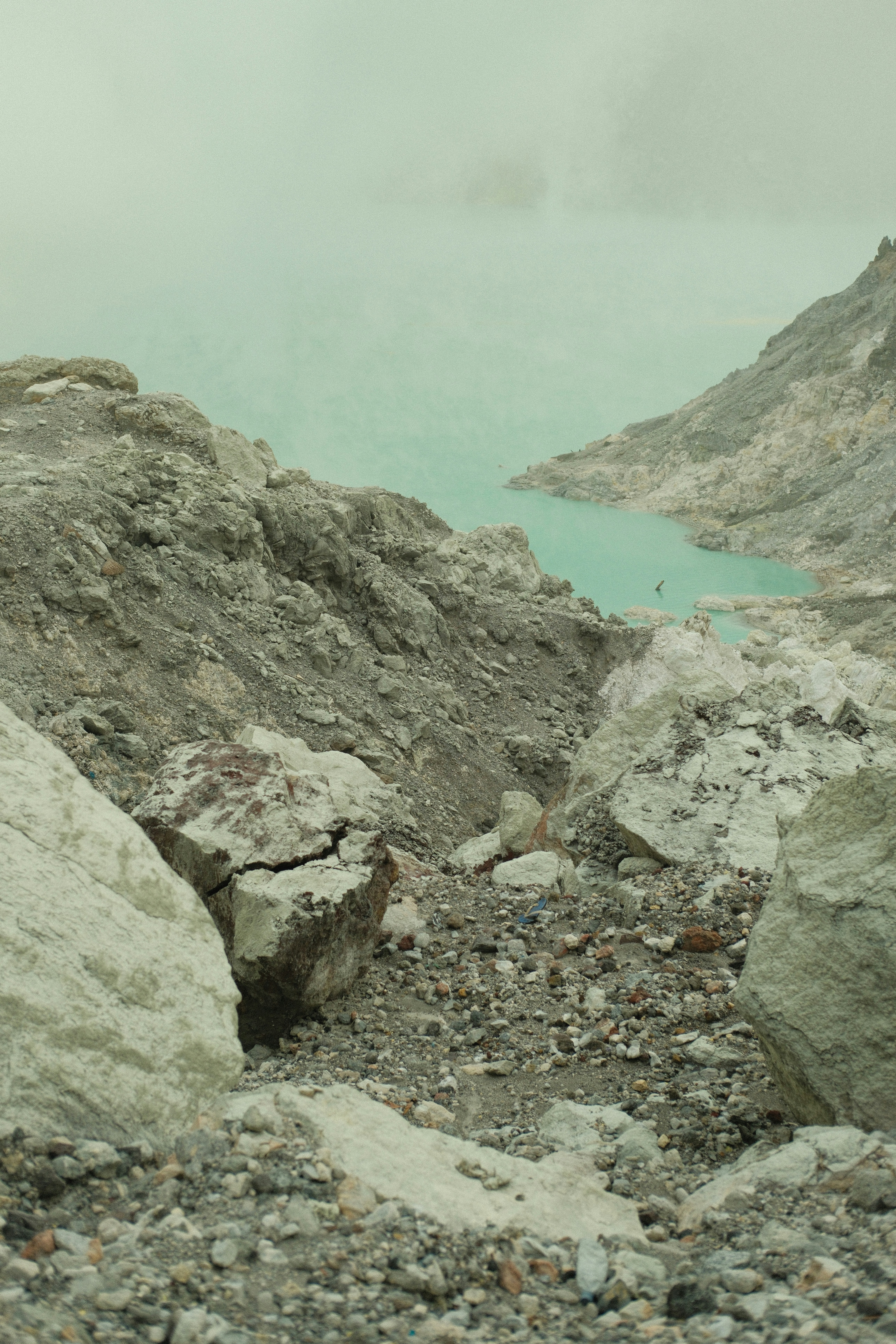 Rugged descent toward a turquoise crater lake
