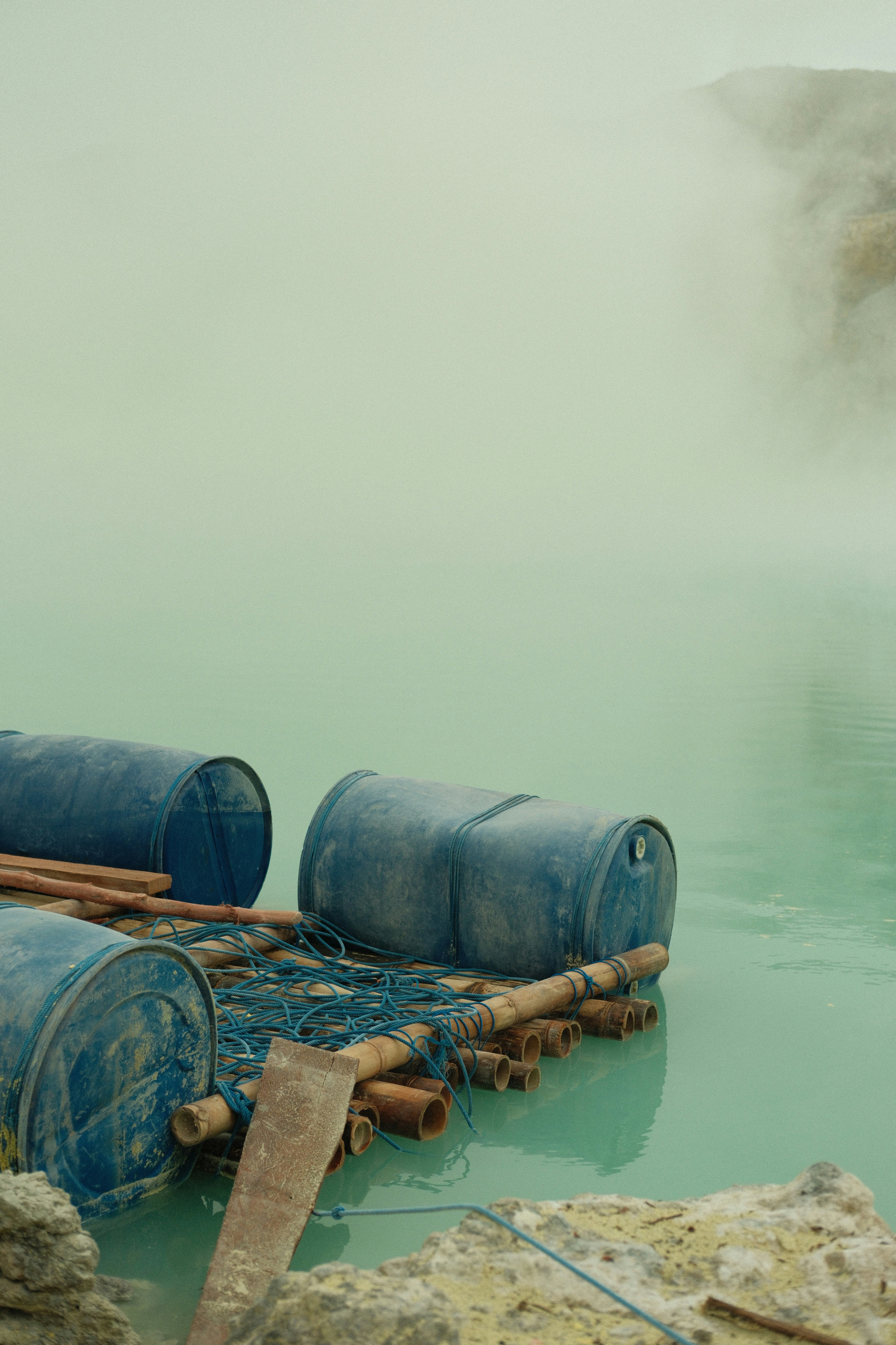 A group of barrels sitting on top of a body of water photo – Free Rock ...