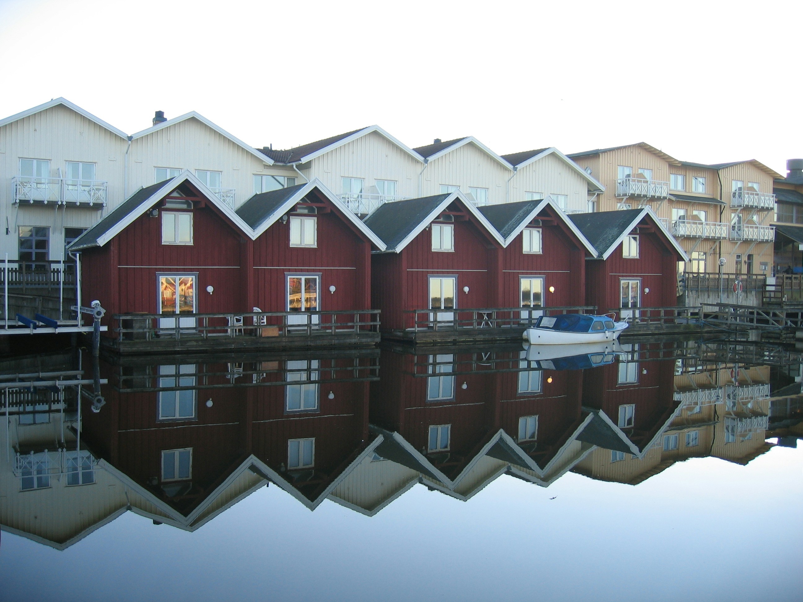 a row of red houses sitting next to a body of water