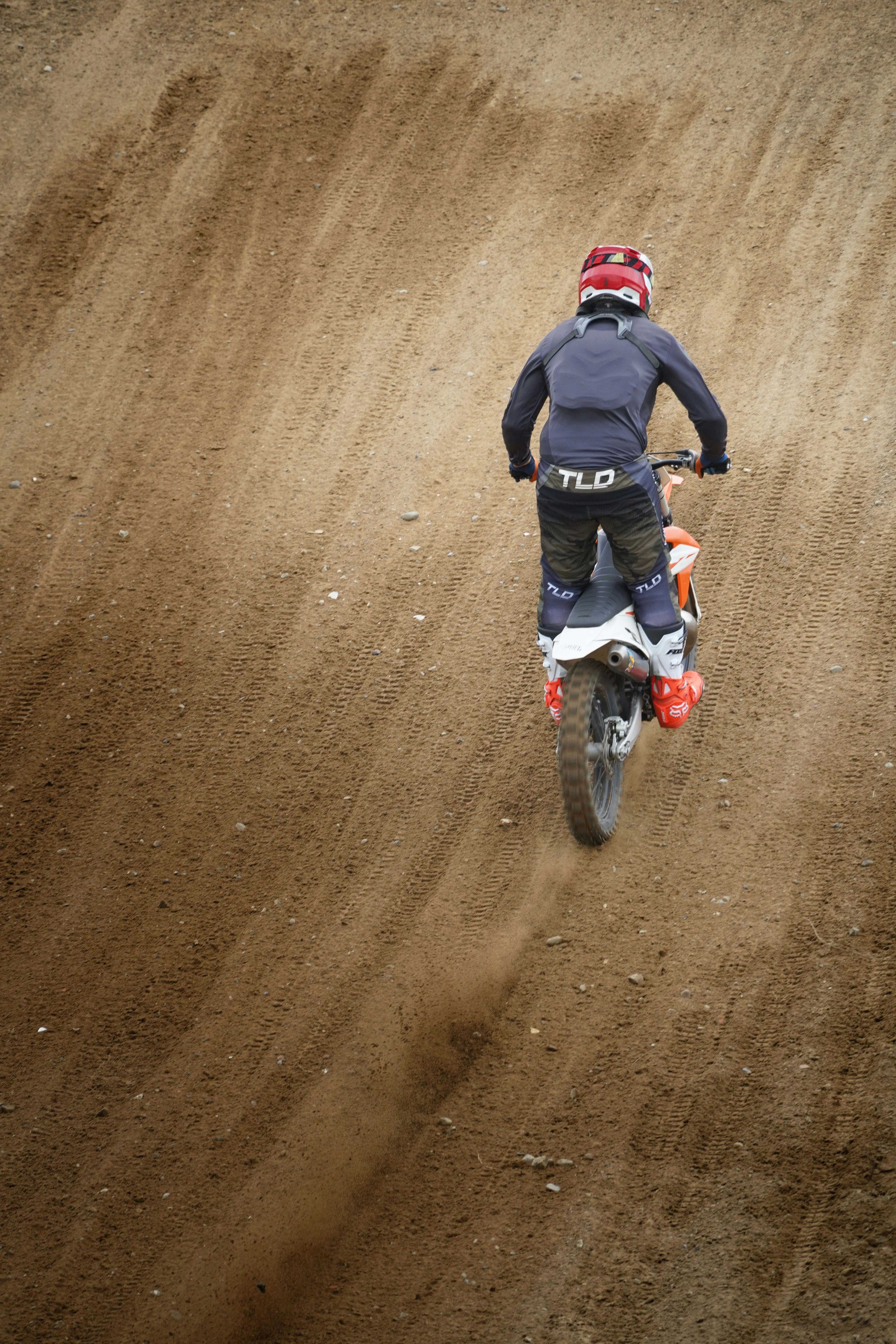 Midair Ascent on a Dusty Motocross Slope