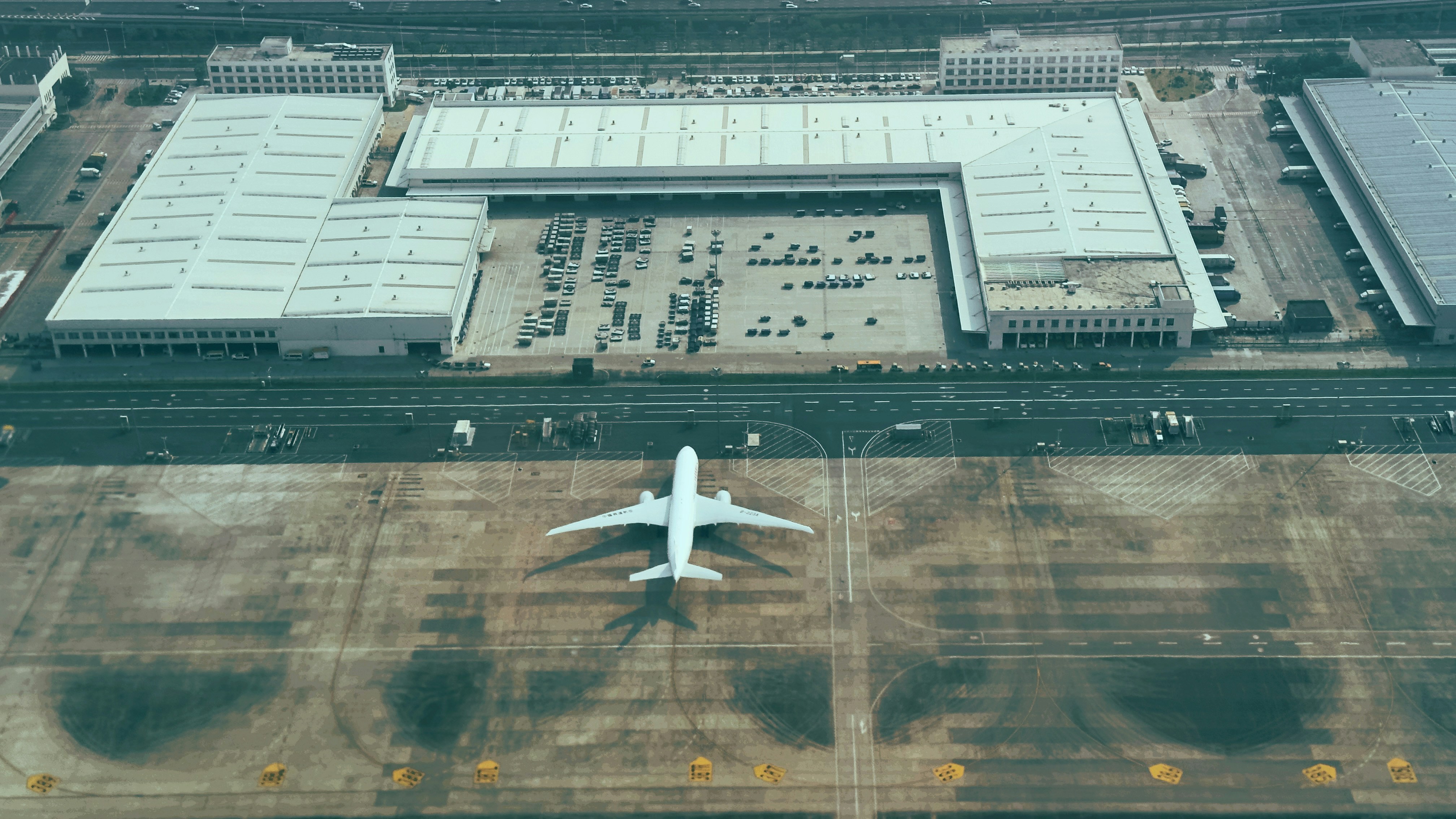 An aerial view of an airport with an airplane photo – Free Building ...