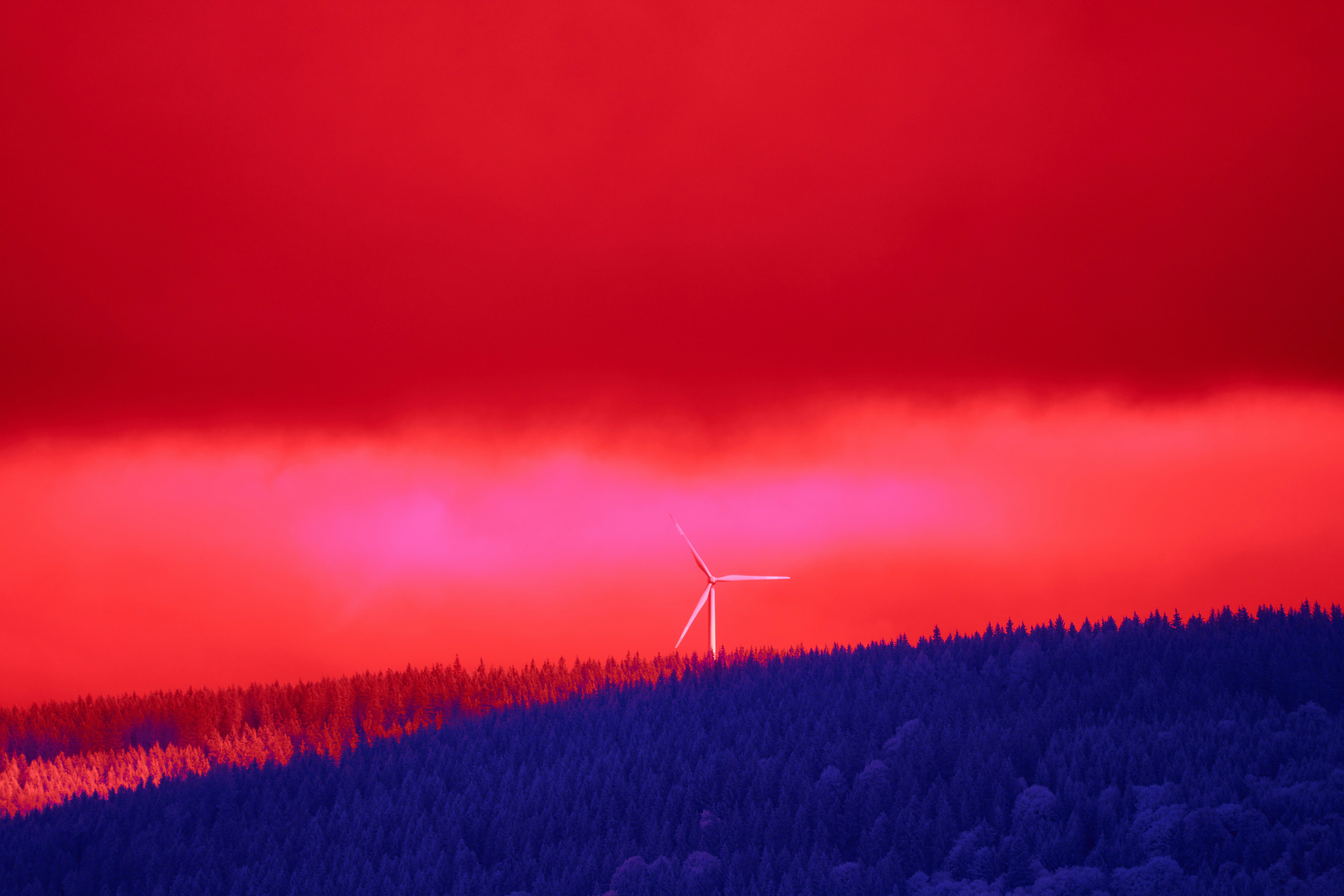 A red sky with a wind turbine in the distance photo – Free Backgrounds ...
