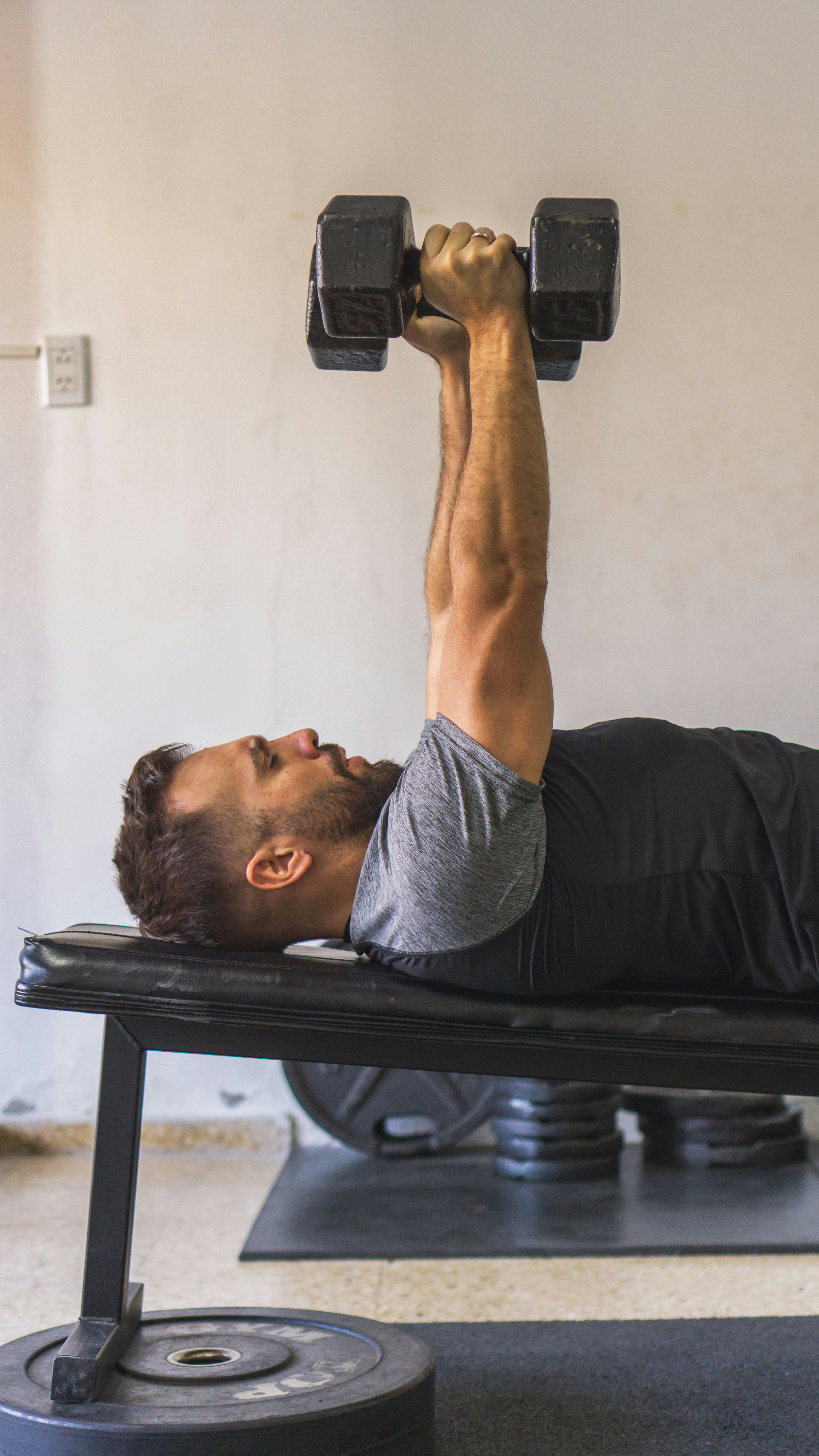 A man doing a bench press with a dumbbell photo – Free Adult Image on ...
