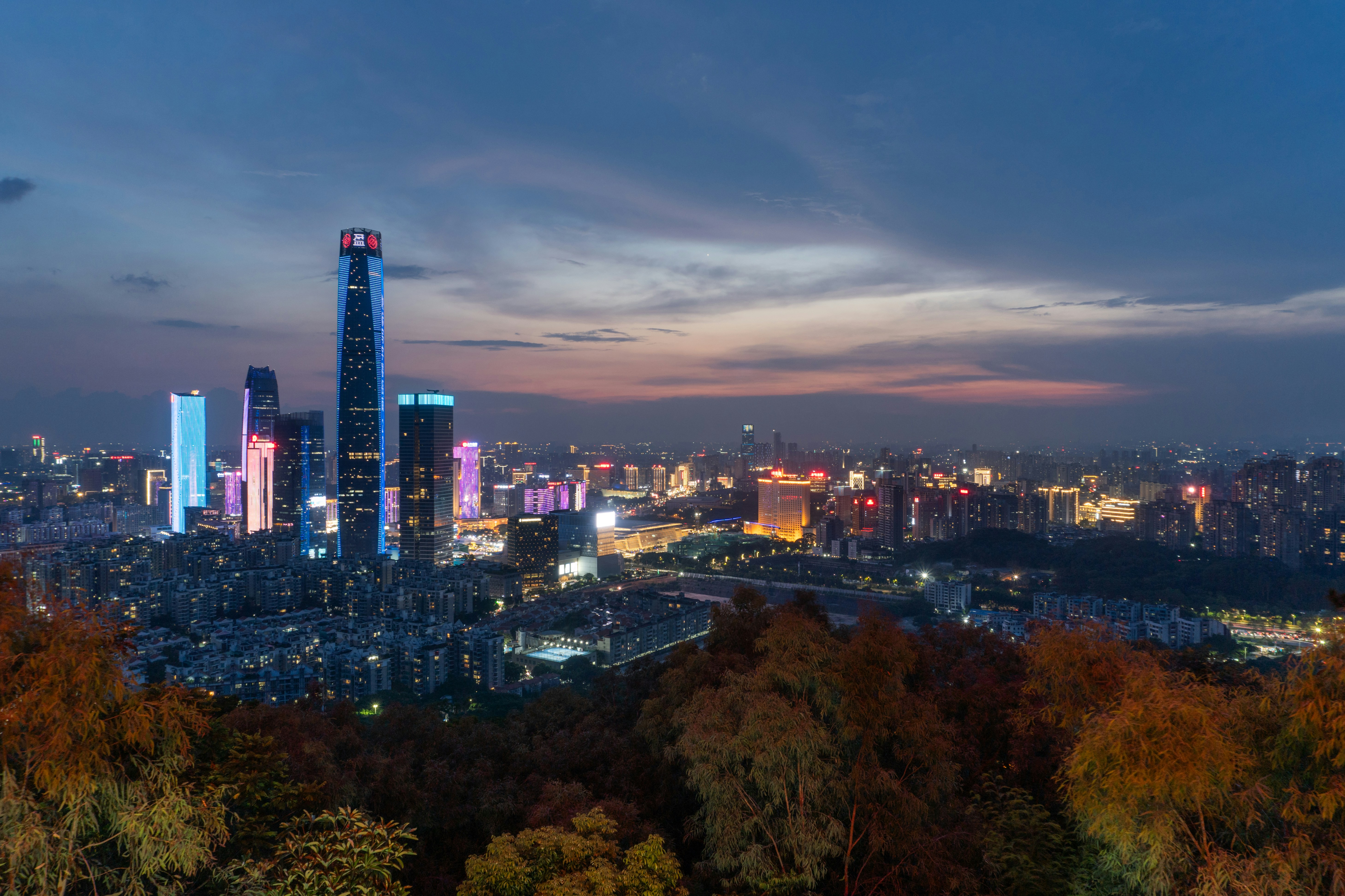 Dusk Skyline: Neon Towers Over Autumn Hills