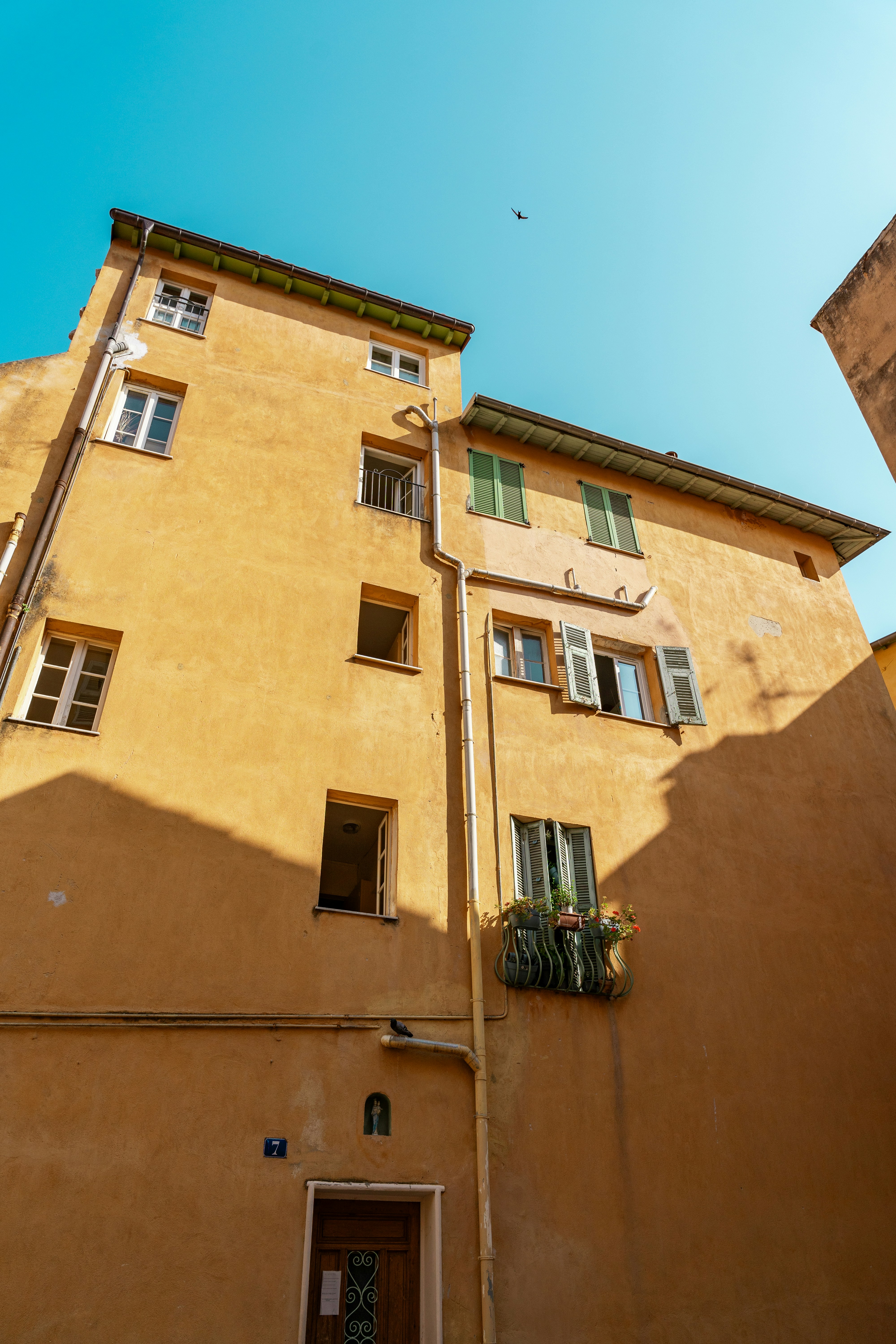 Un grand bâtiment jaune avec des fenêtres et une porte photo – Photo ...