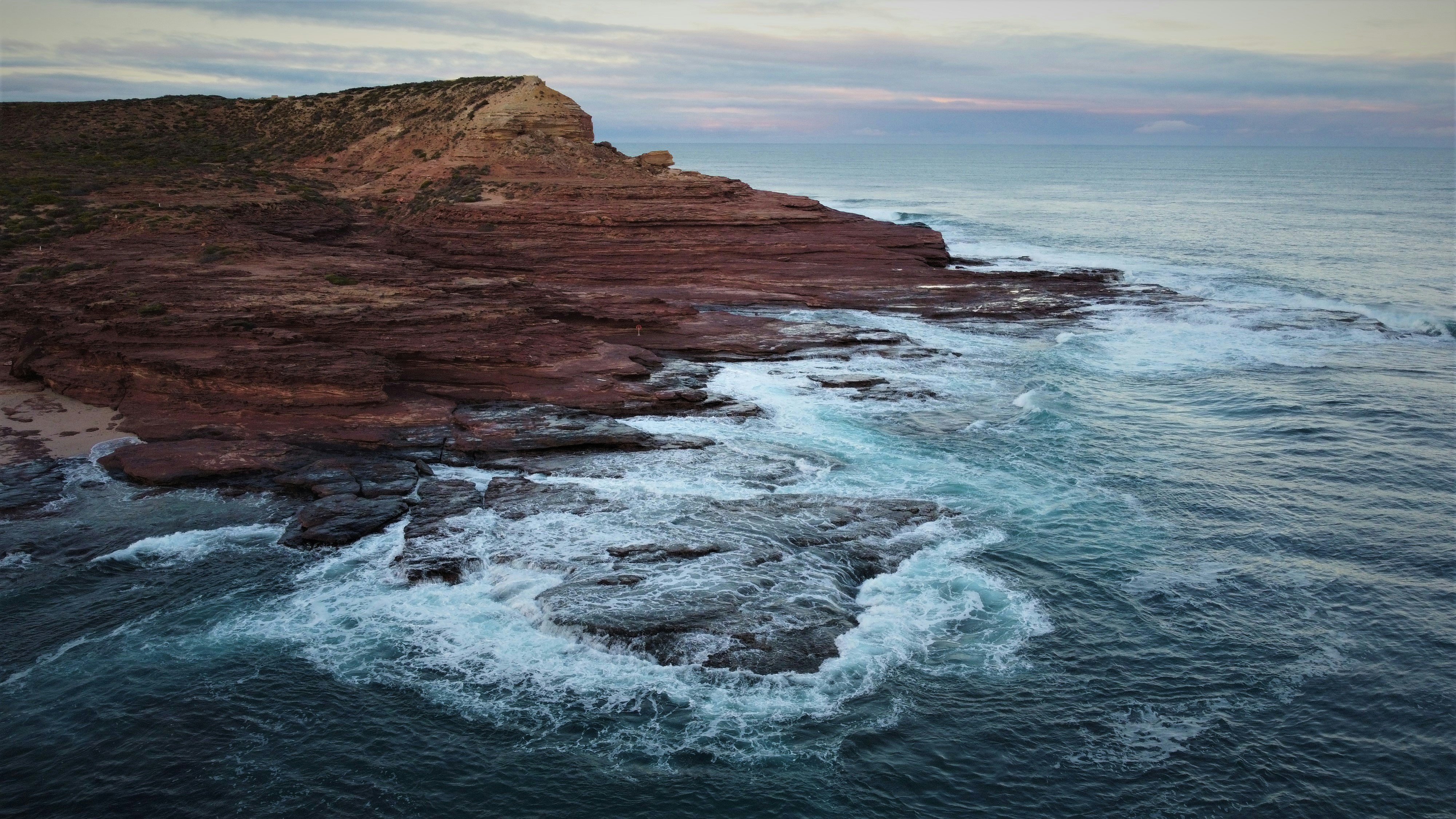 a large body of water next to a rocky shore