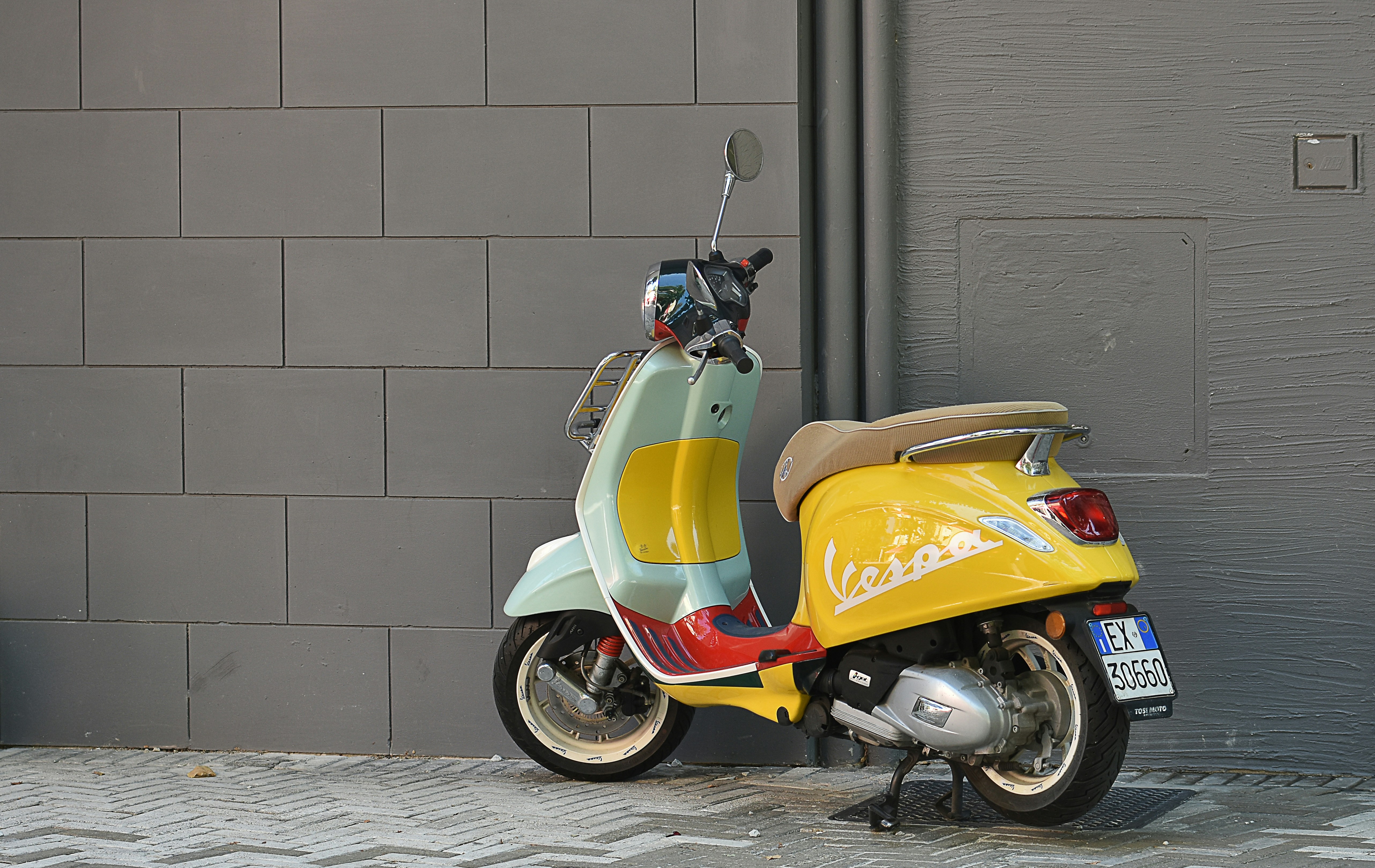 Pastel Vespa Resting Against a Quiet City Wall