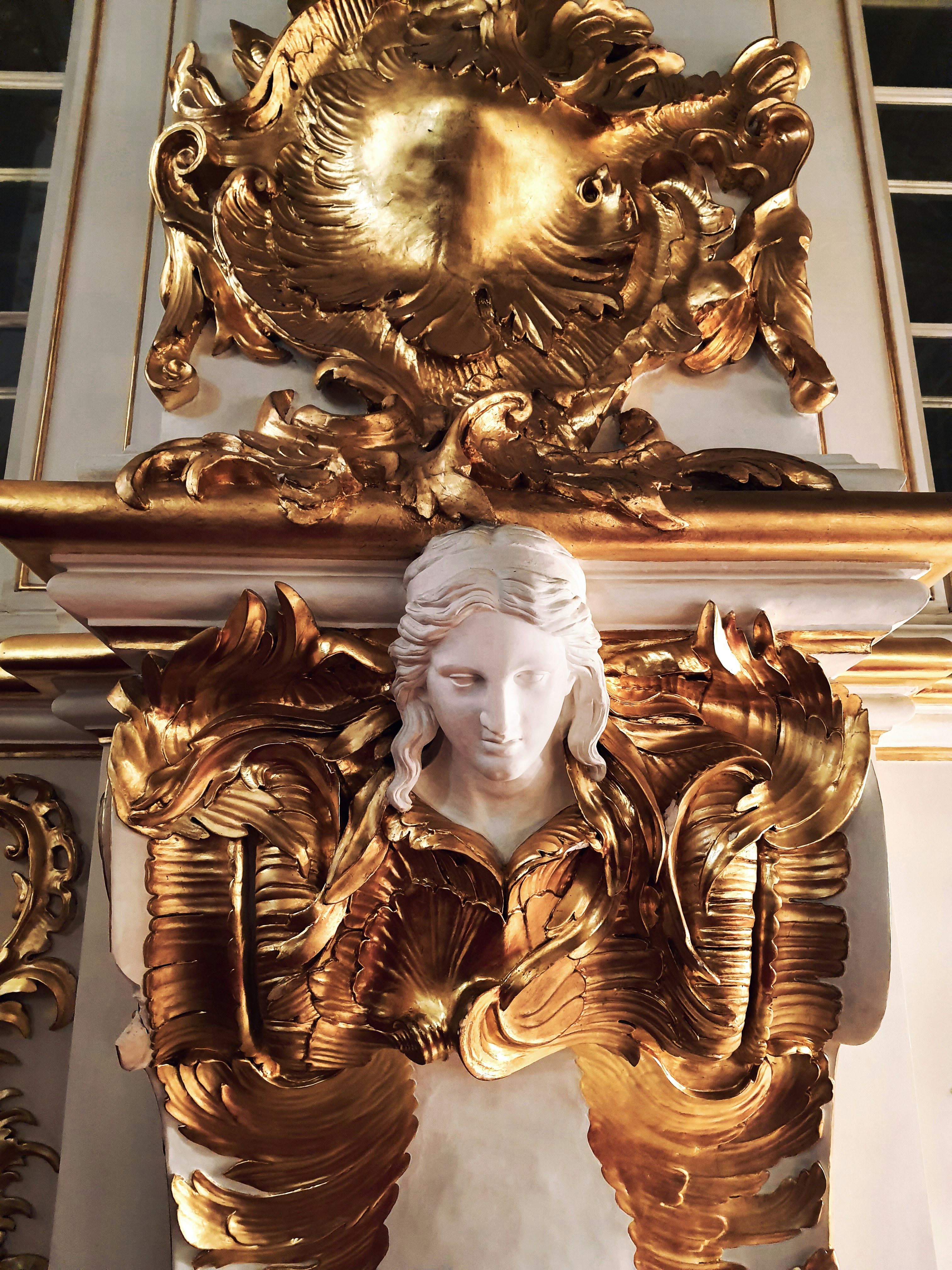 A gold statue of a woman with her hands in her pockets photo – Free ...