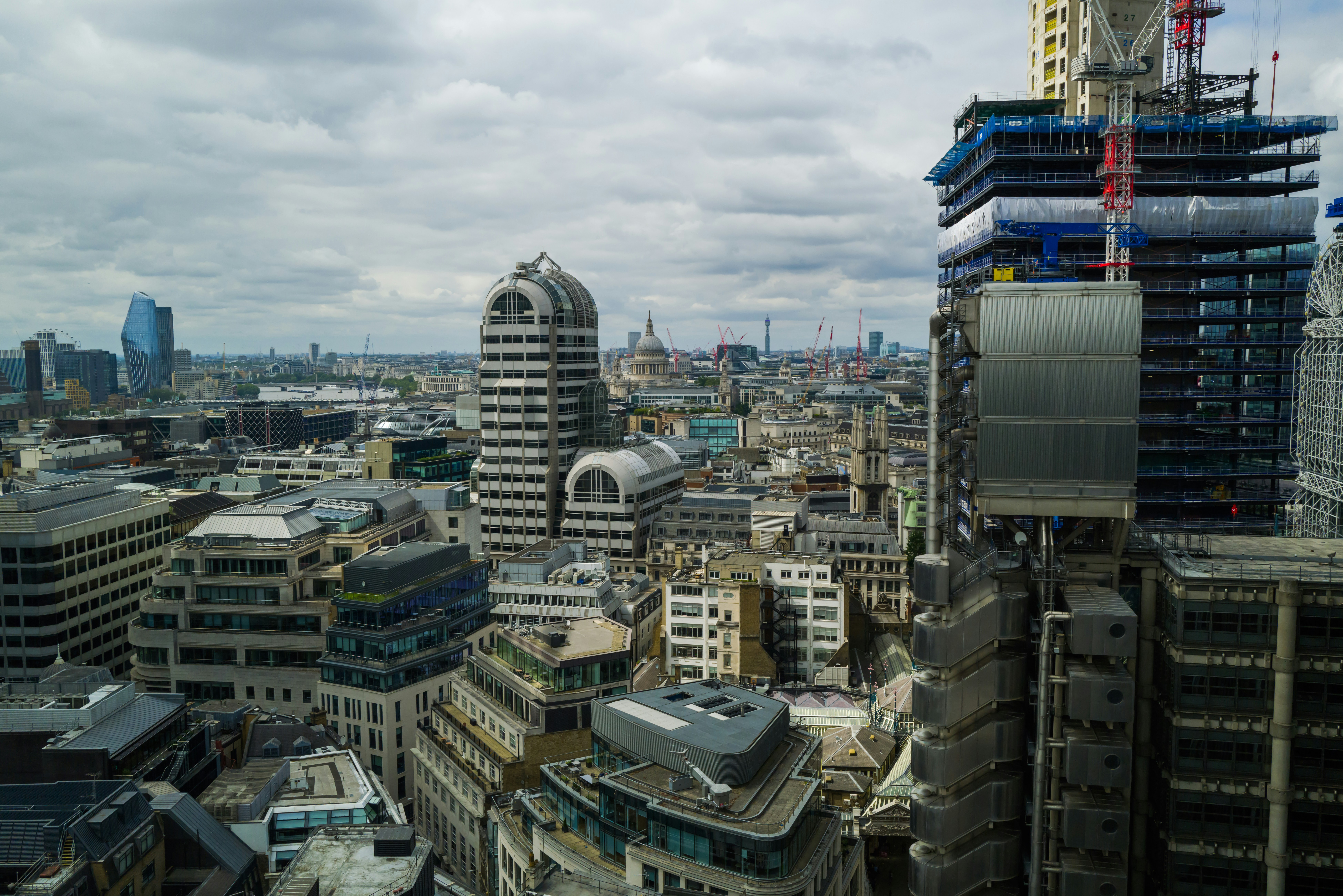 Cranes Crown a Dense Cityscape Beneath a Brooding Sky