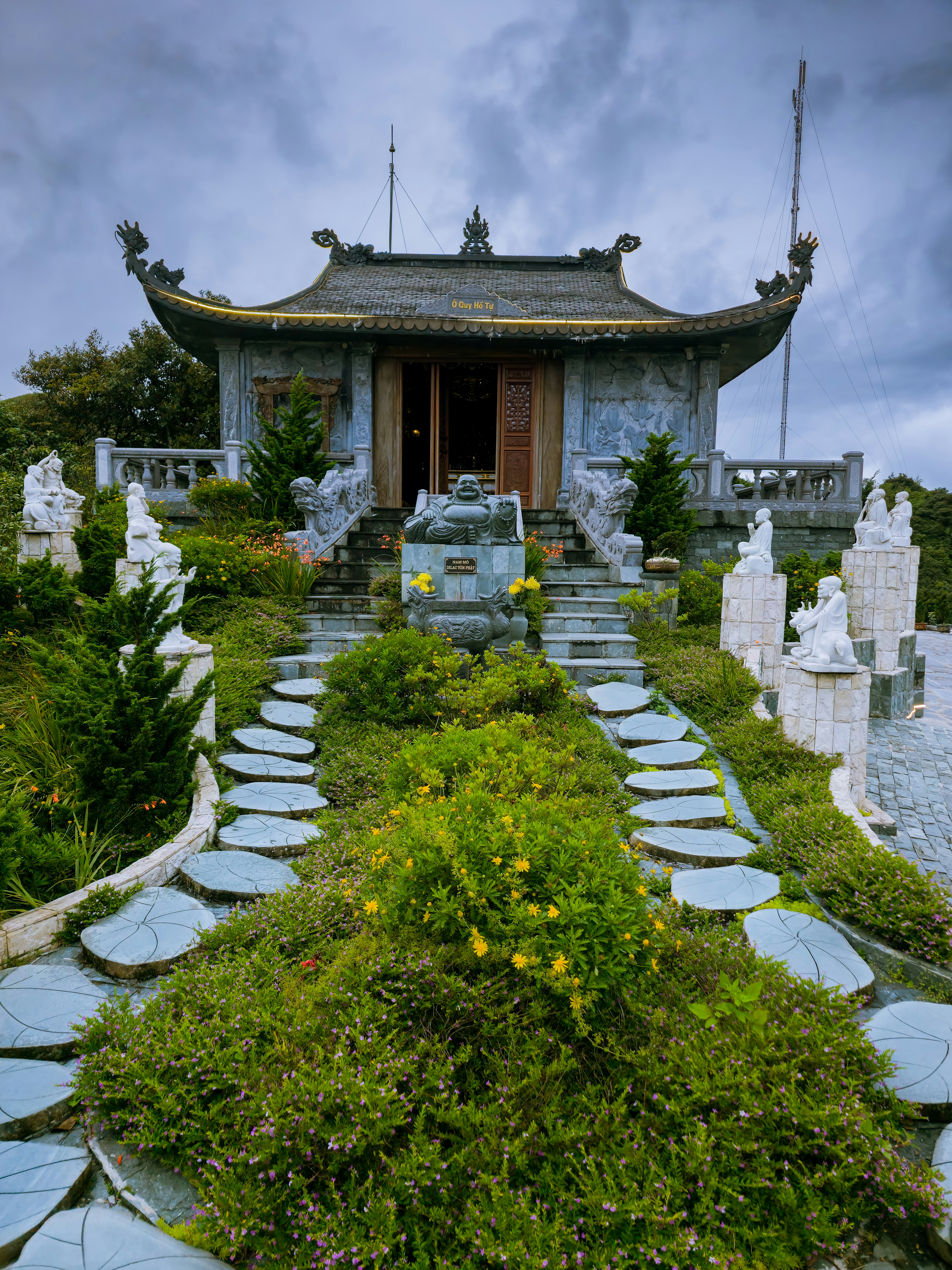 Stone Path to a Hidden Shrine: Guardian Statues Framing a Curved-Roof Temple