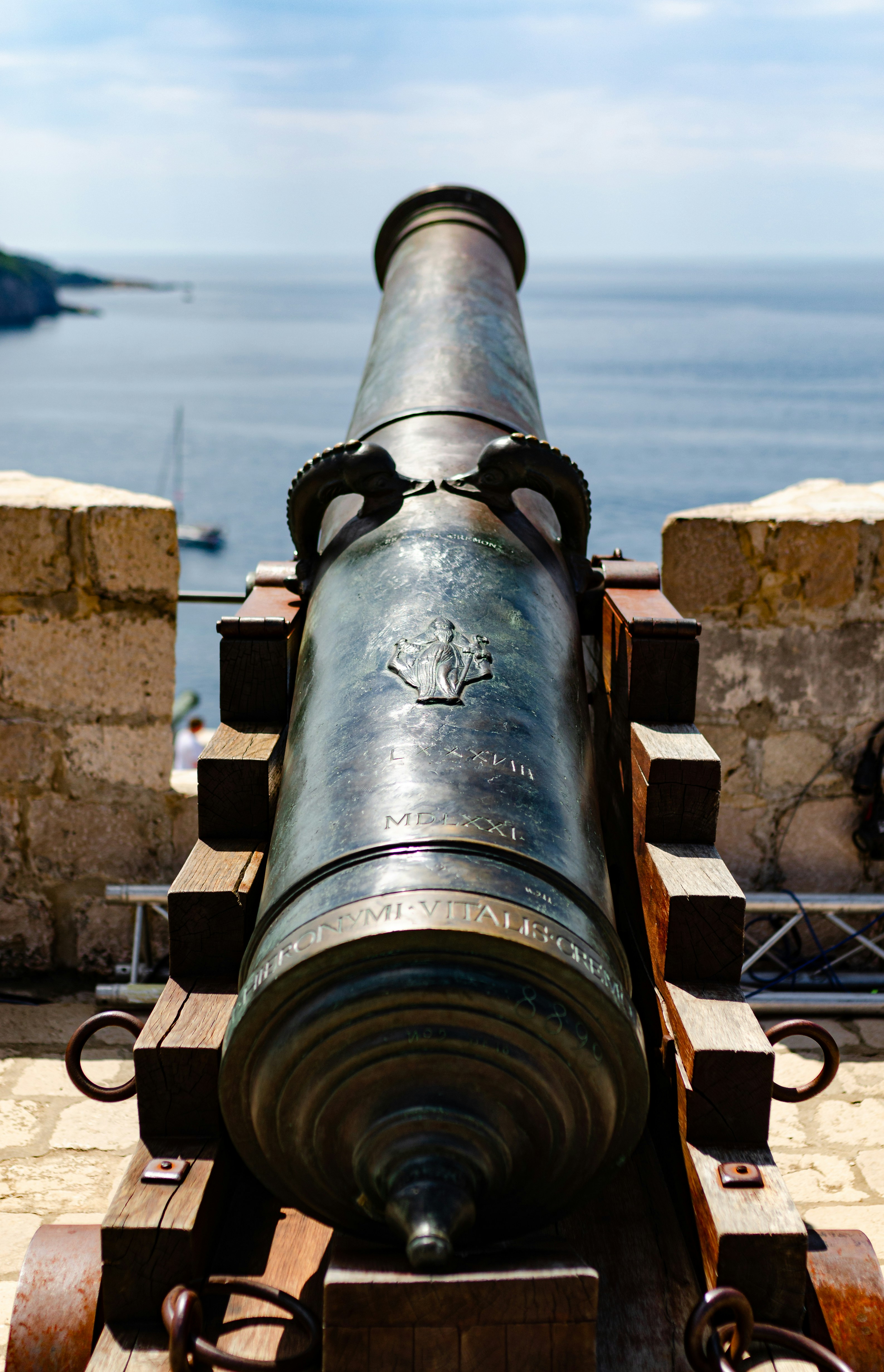 A large metal cannon sitting on top of a stone wall photo – Free ...