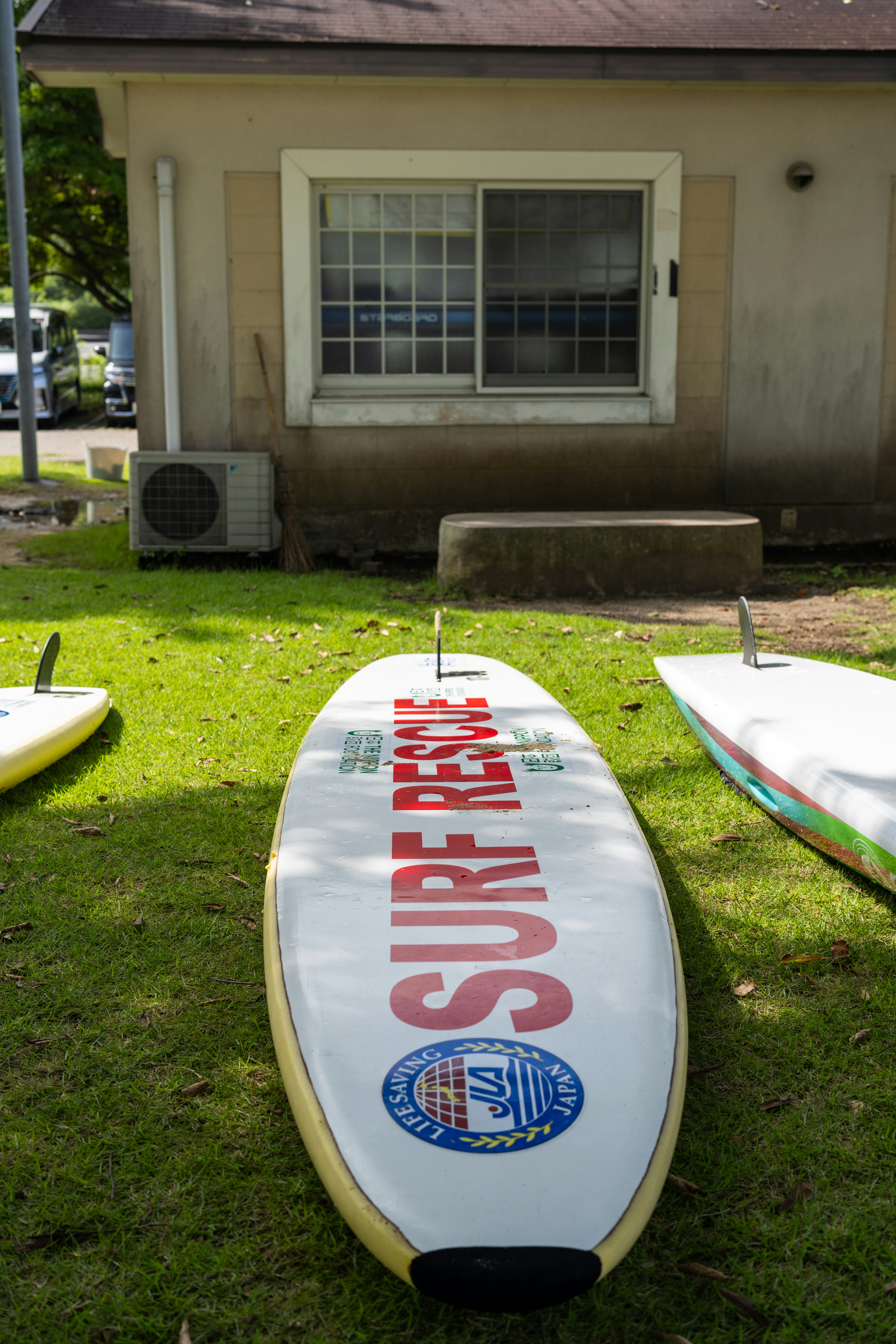 a surfboard sitting in the grass in front of a house