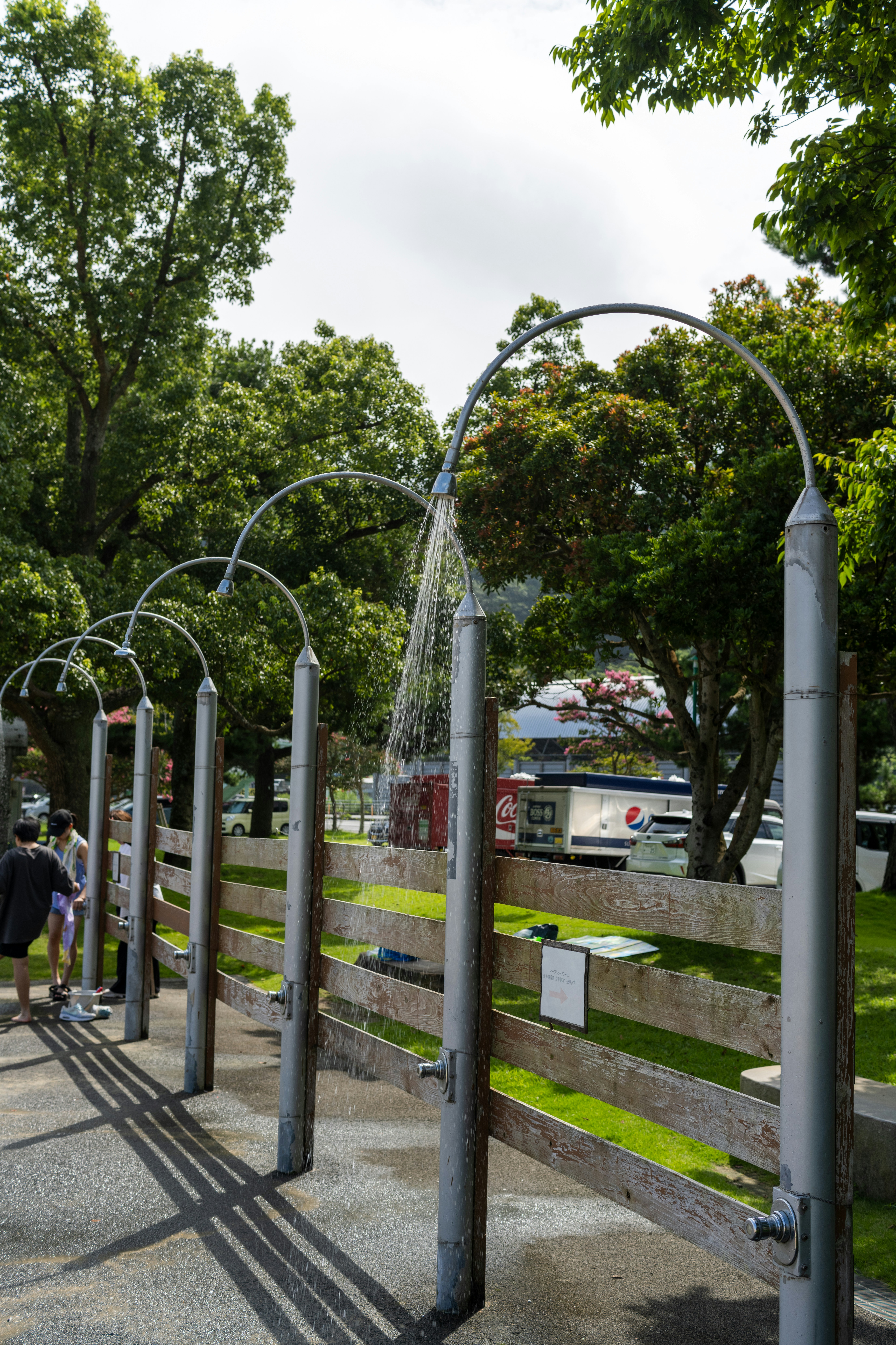 A wooden fence with a water spout in the middle of it photo – Free ...
