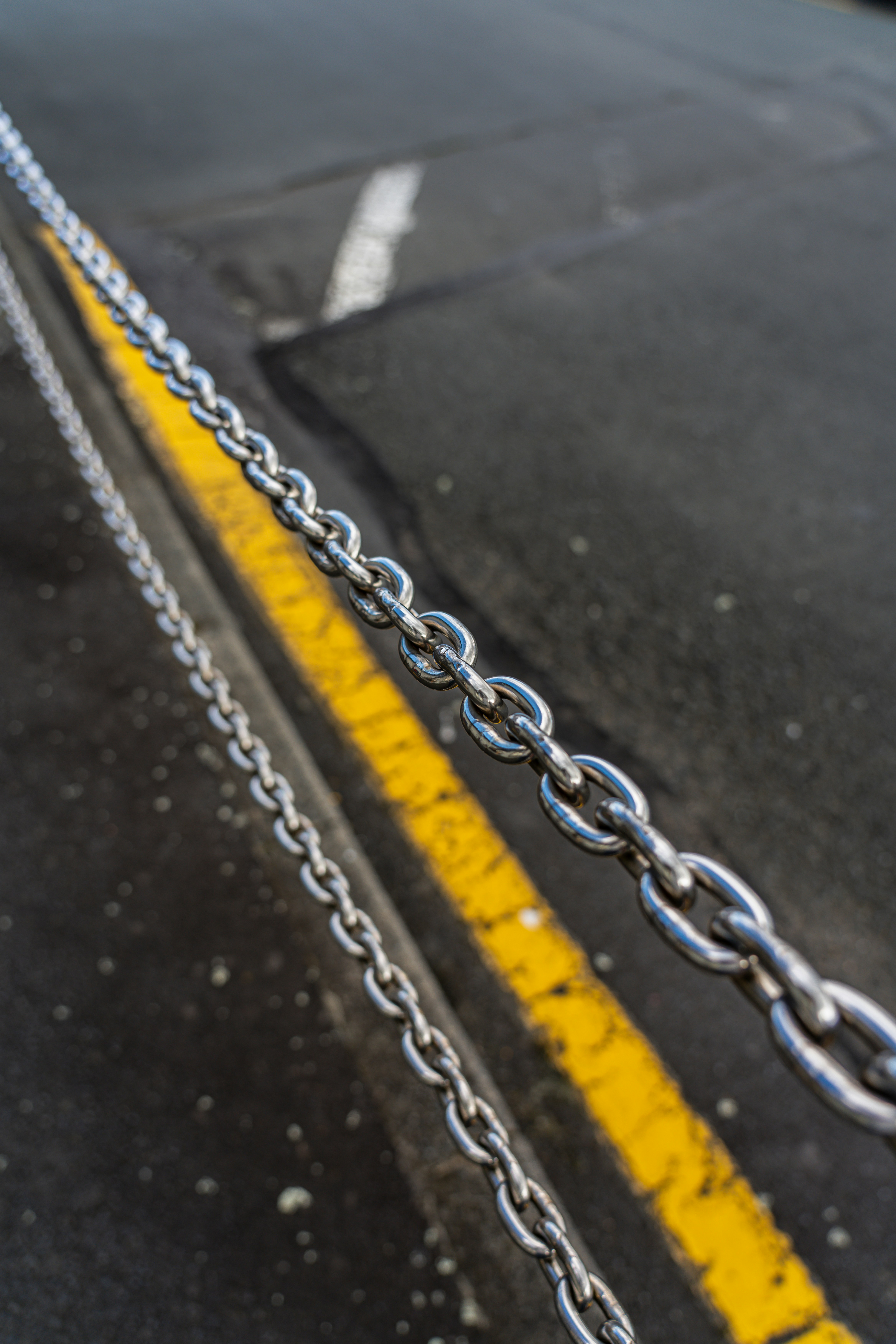 A close up of a chain on the side of a road photo – Free Chain Image on ...