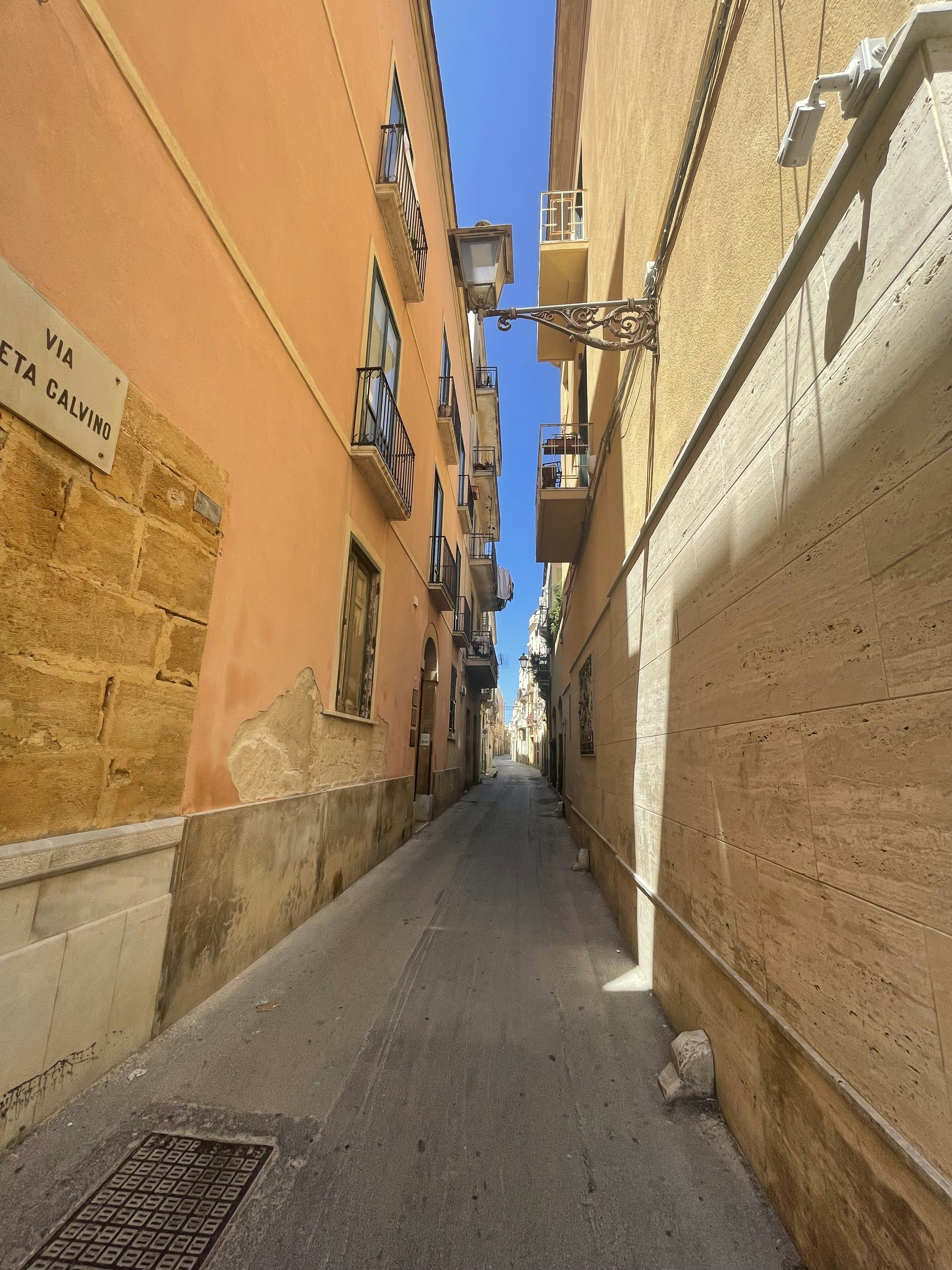 A narrow city street lined with tall buildings photo – Free Alley Image ...