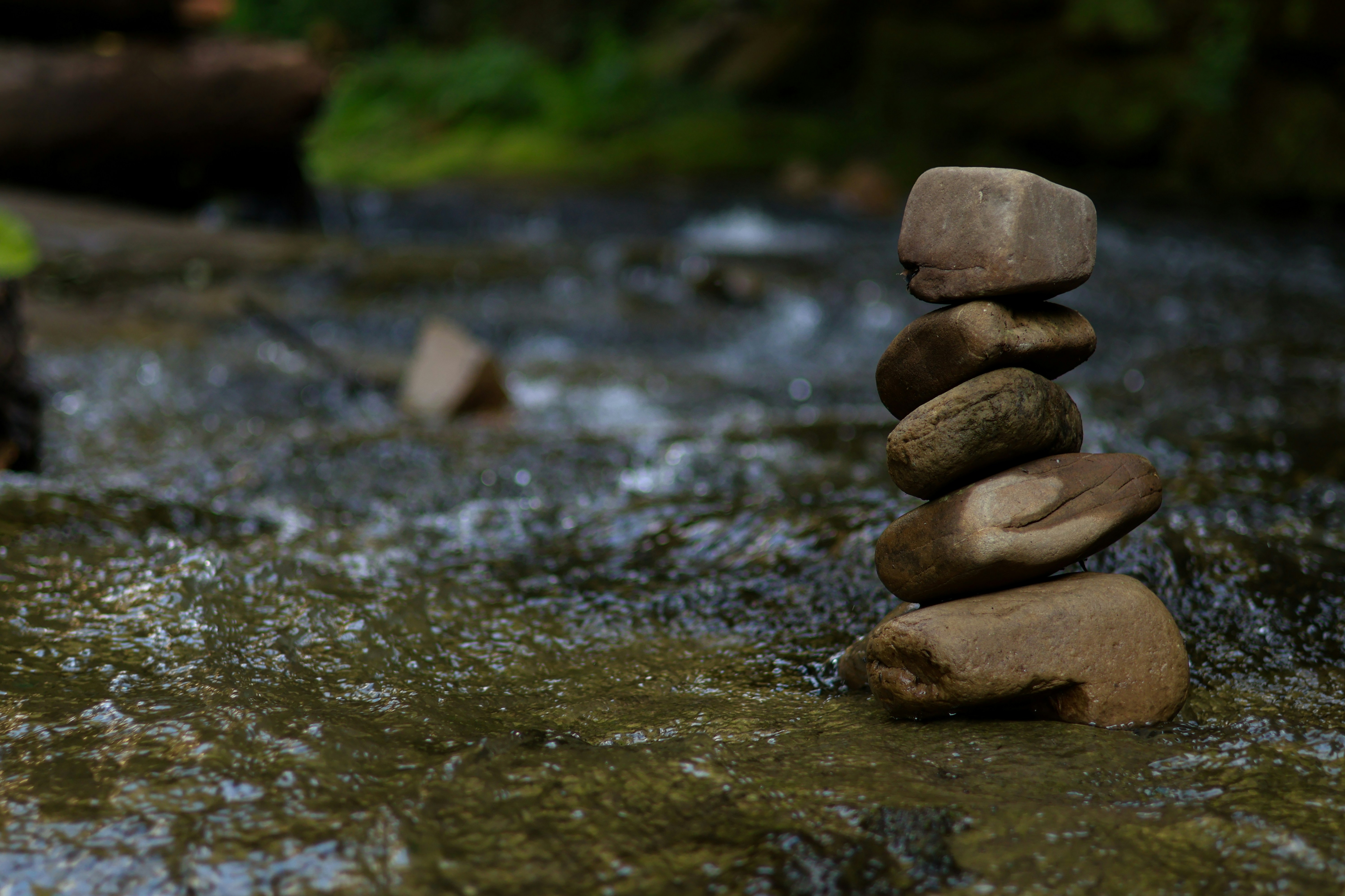 A stack of rocks sitting on top of a river photo – Free Lake Image on ...