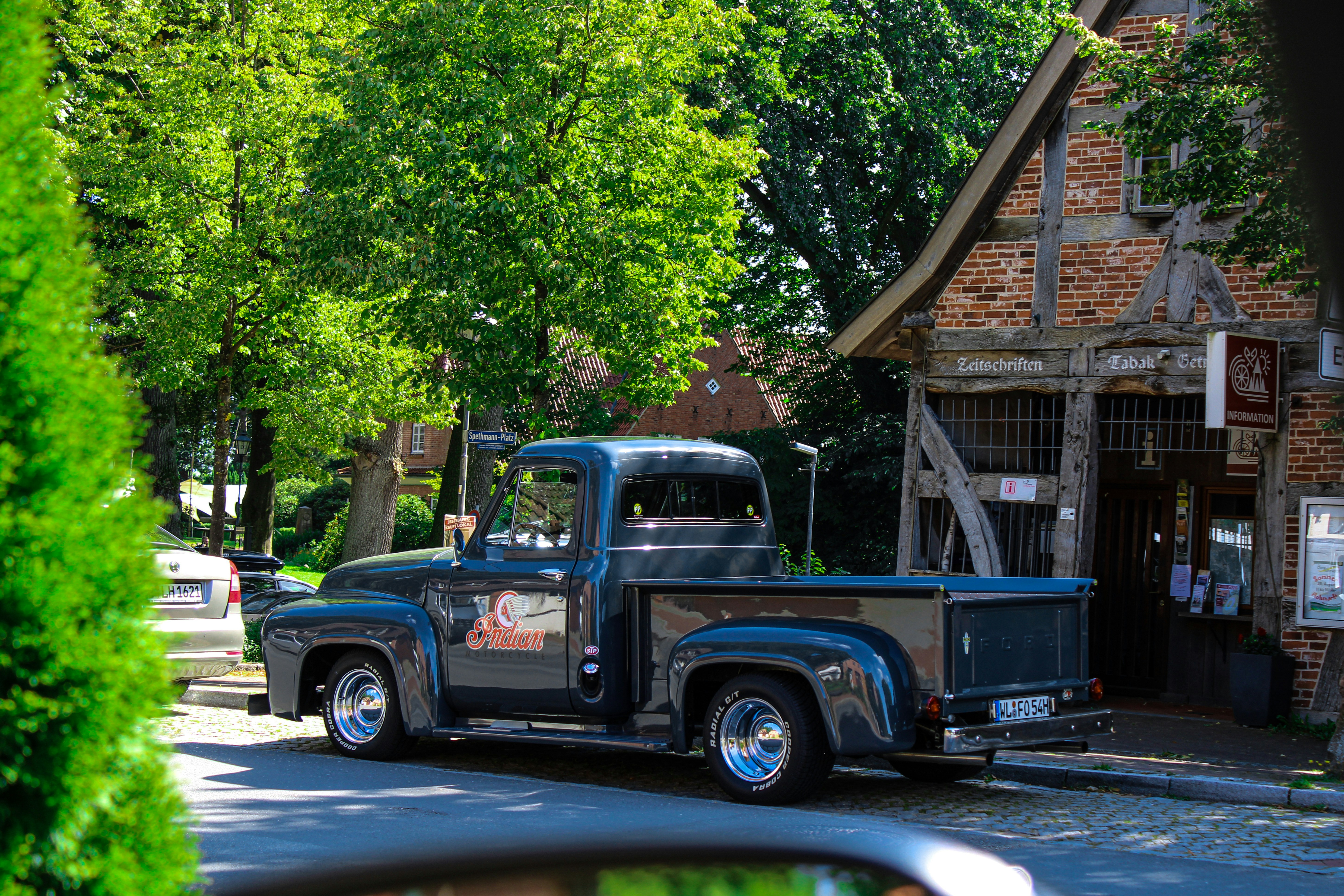 Sunlit Blue Pickup Amid Timber-Framed Charm