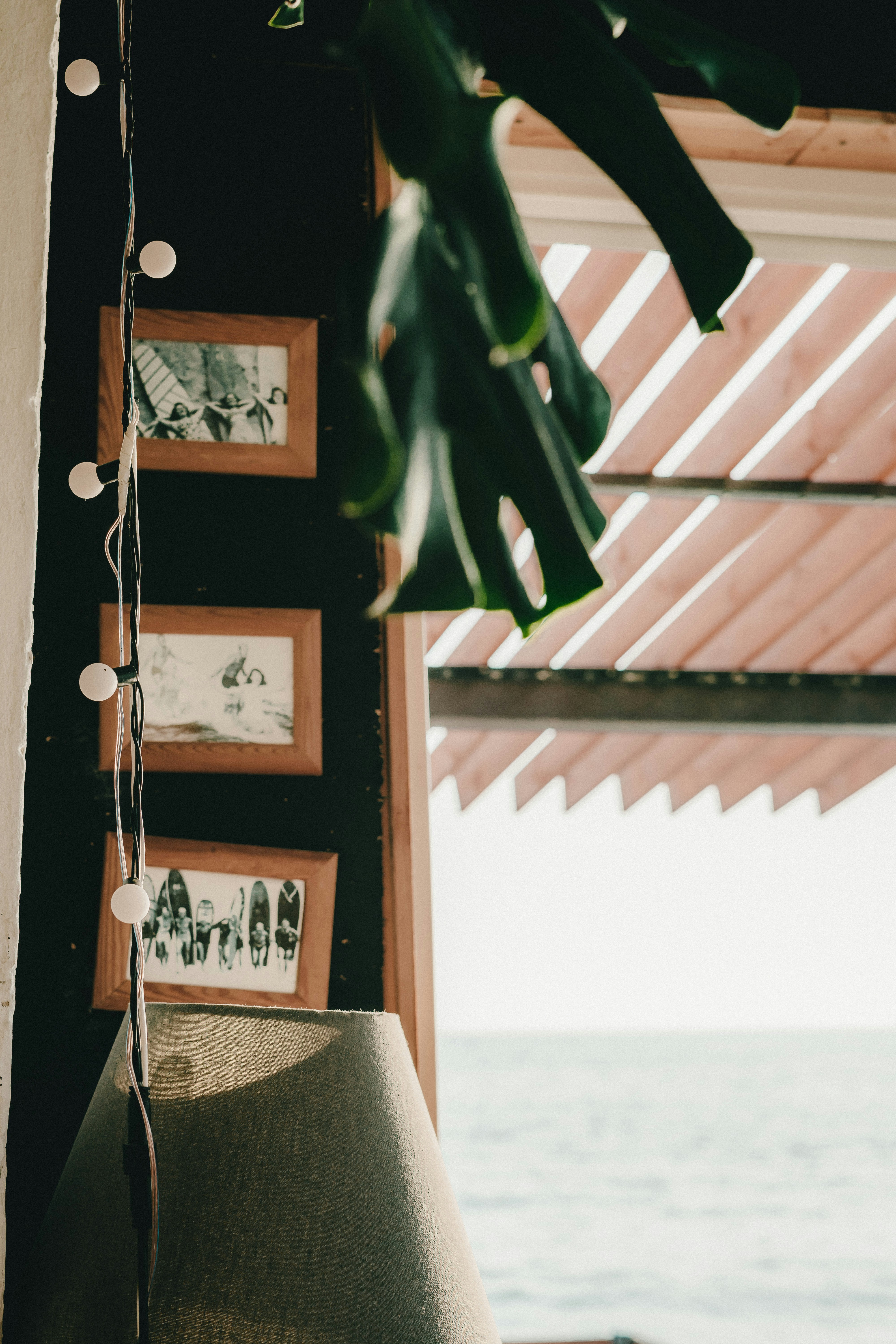 Framed Nostalgia by the Sea: A Cozy Interior with String Lights and Ocean View