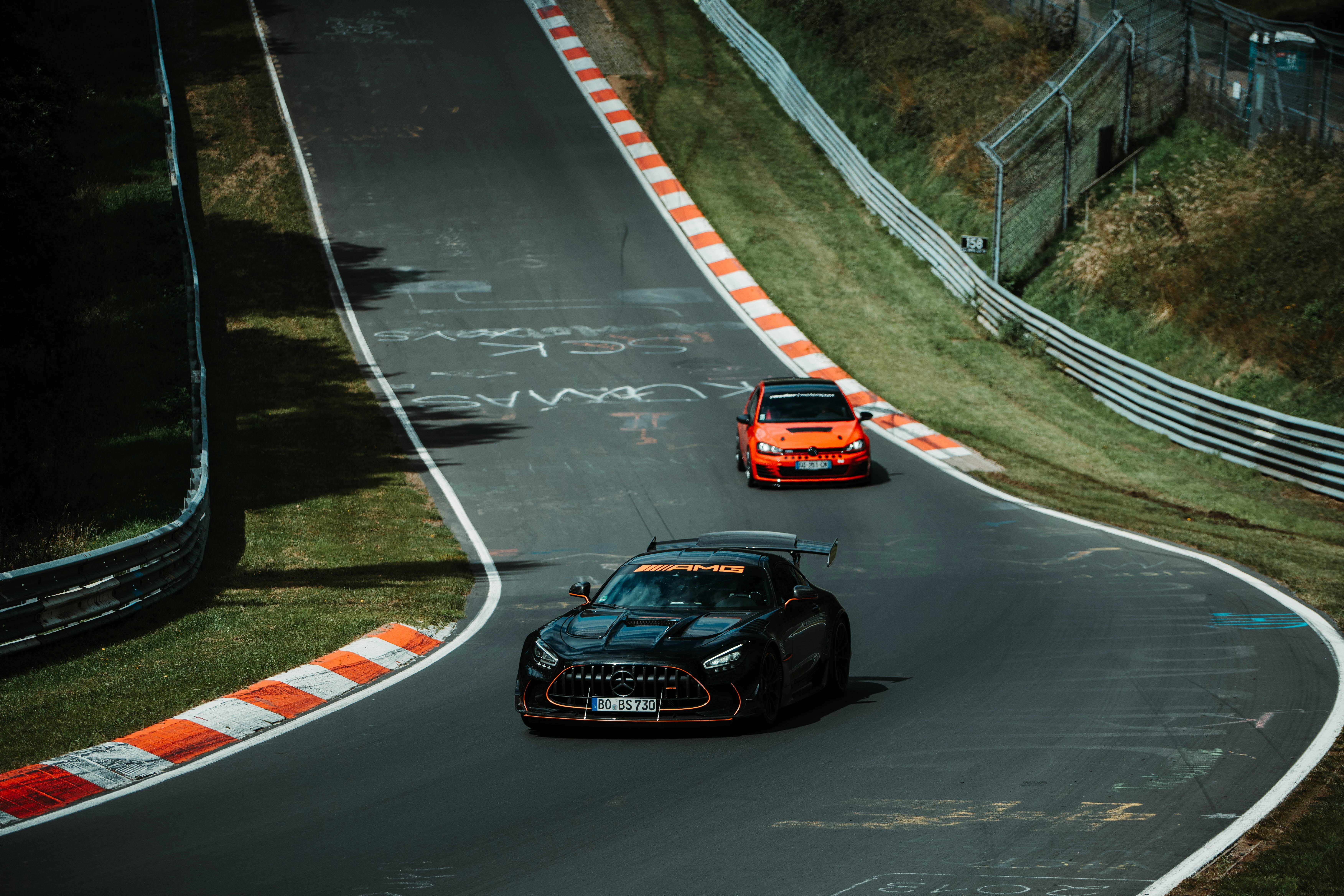Un couple de voitures roulant sur une piste de course photo – Image ...