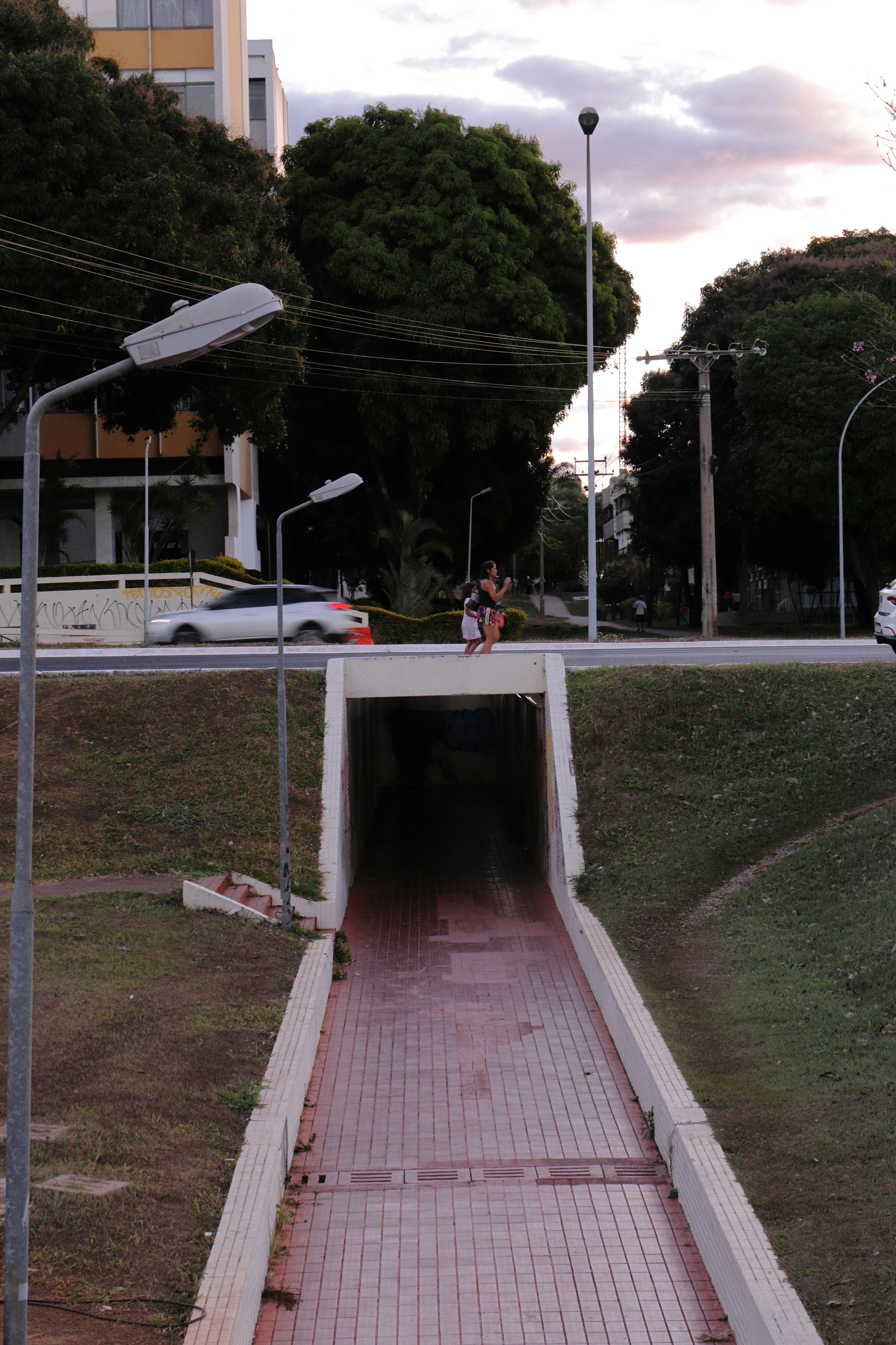Edge of Transit: Two figures at the mouth of a city underpass