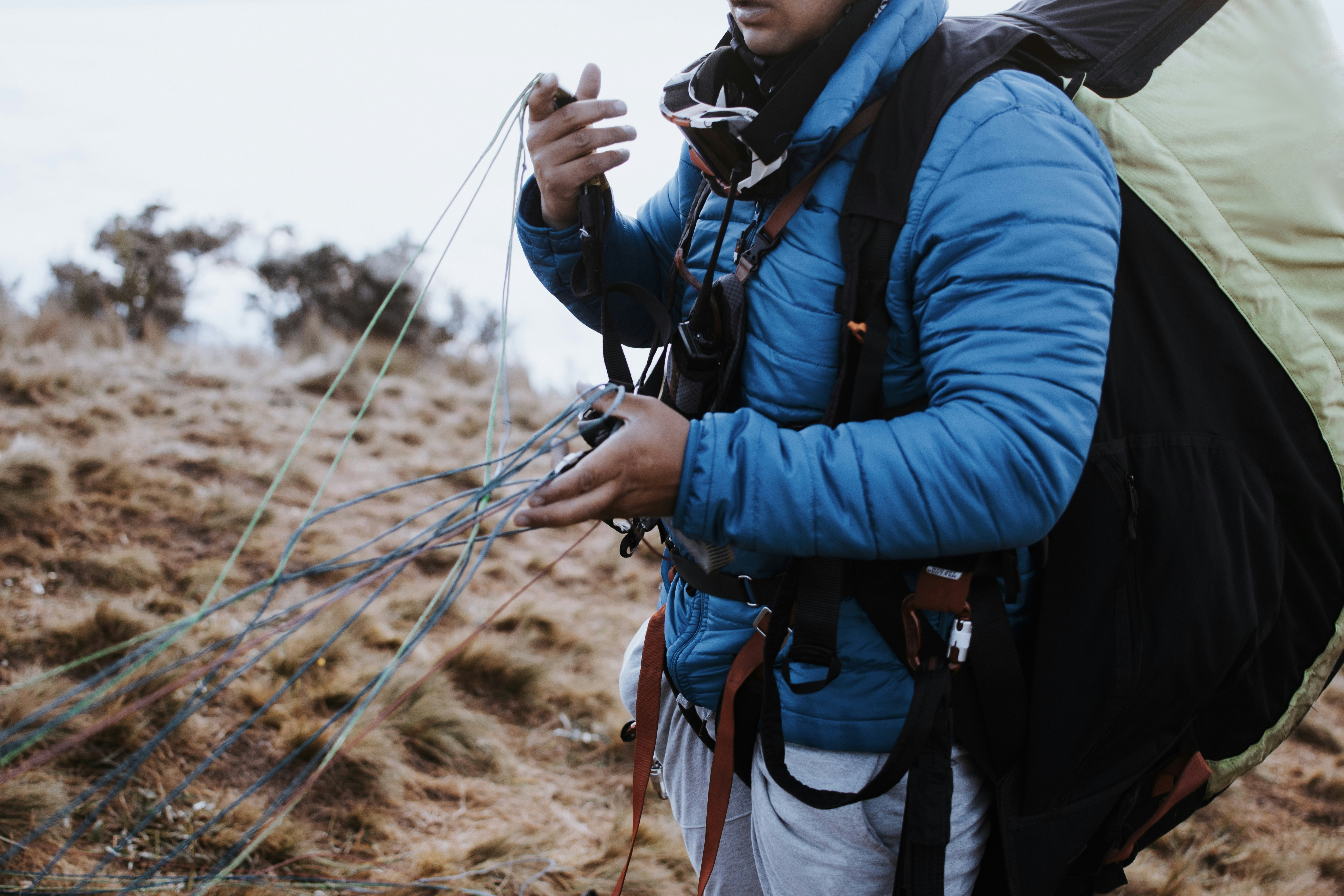 A man prepares his paragliding equipment to fly