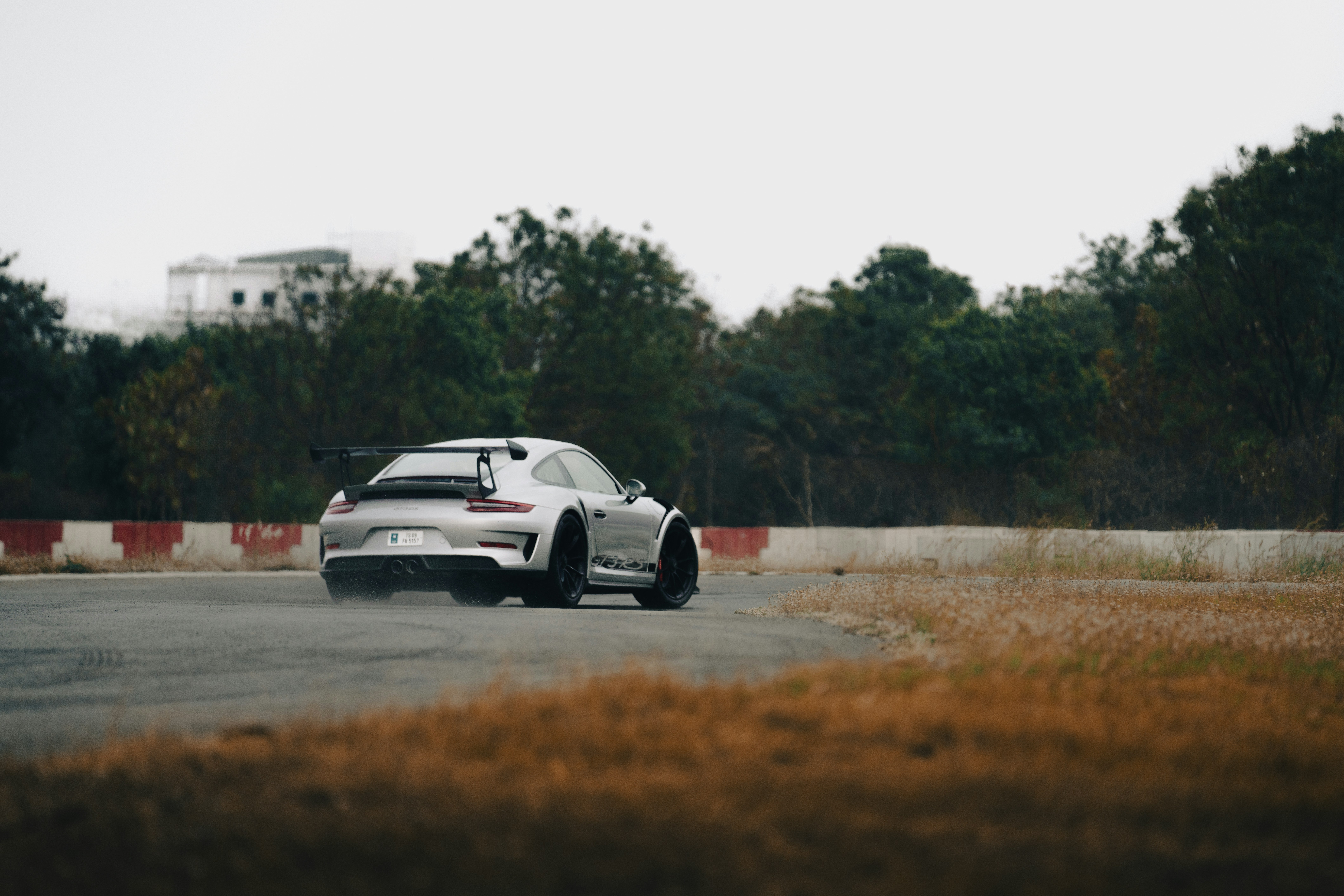 Rear-View Momentum: White Porsche on a Weathered Circuit