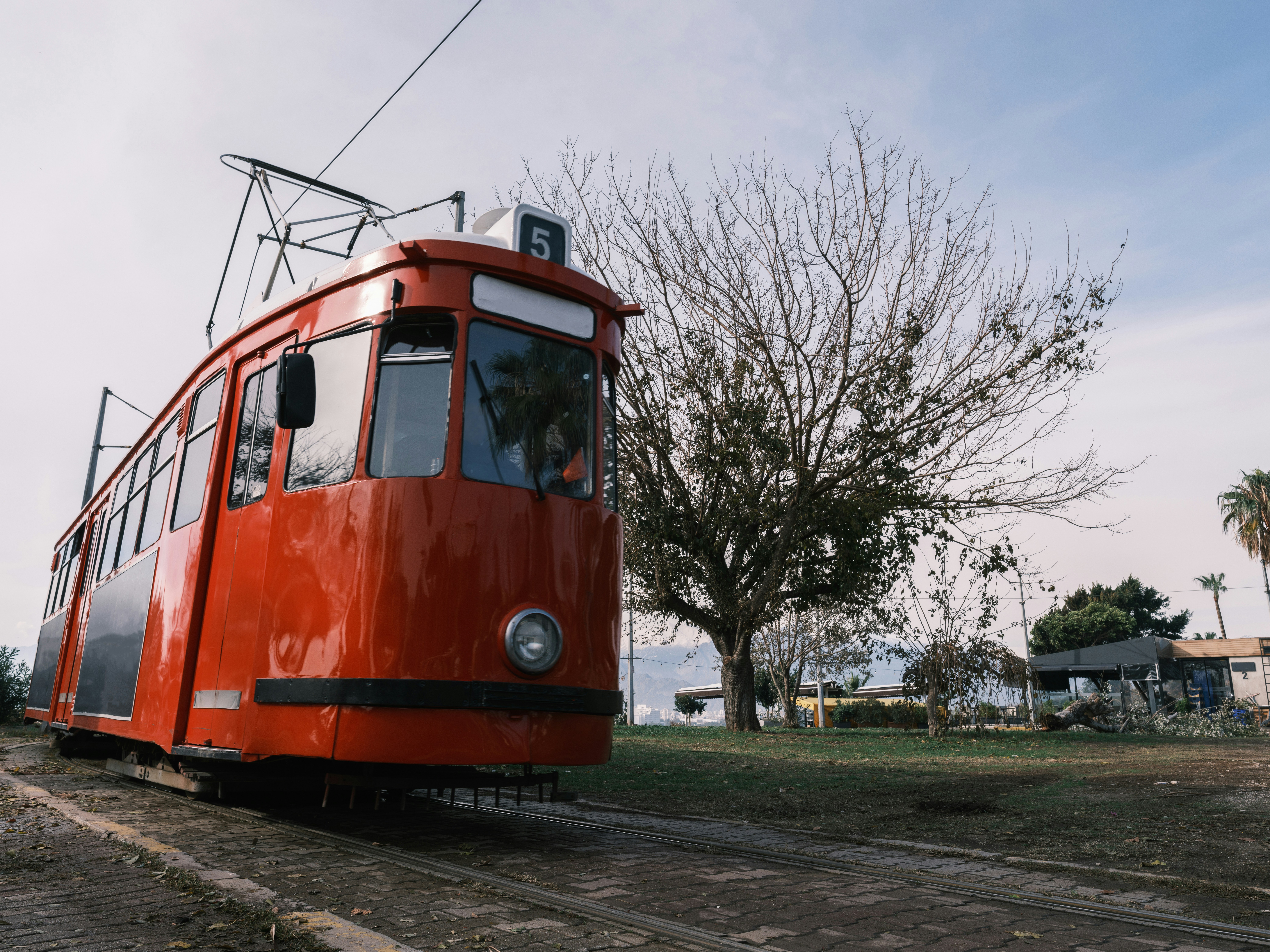 Crimson Streetcar on a Quiet Parkside Track