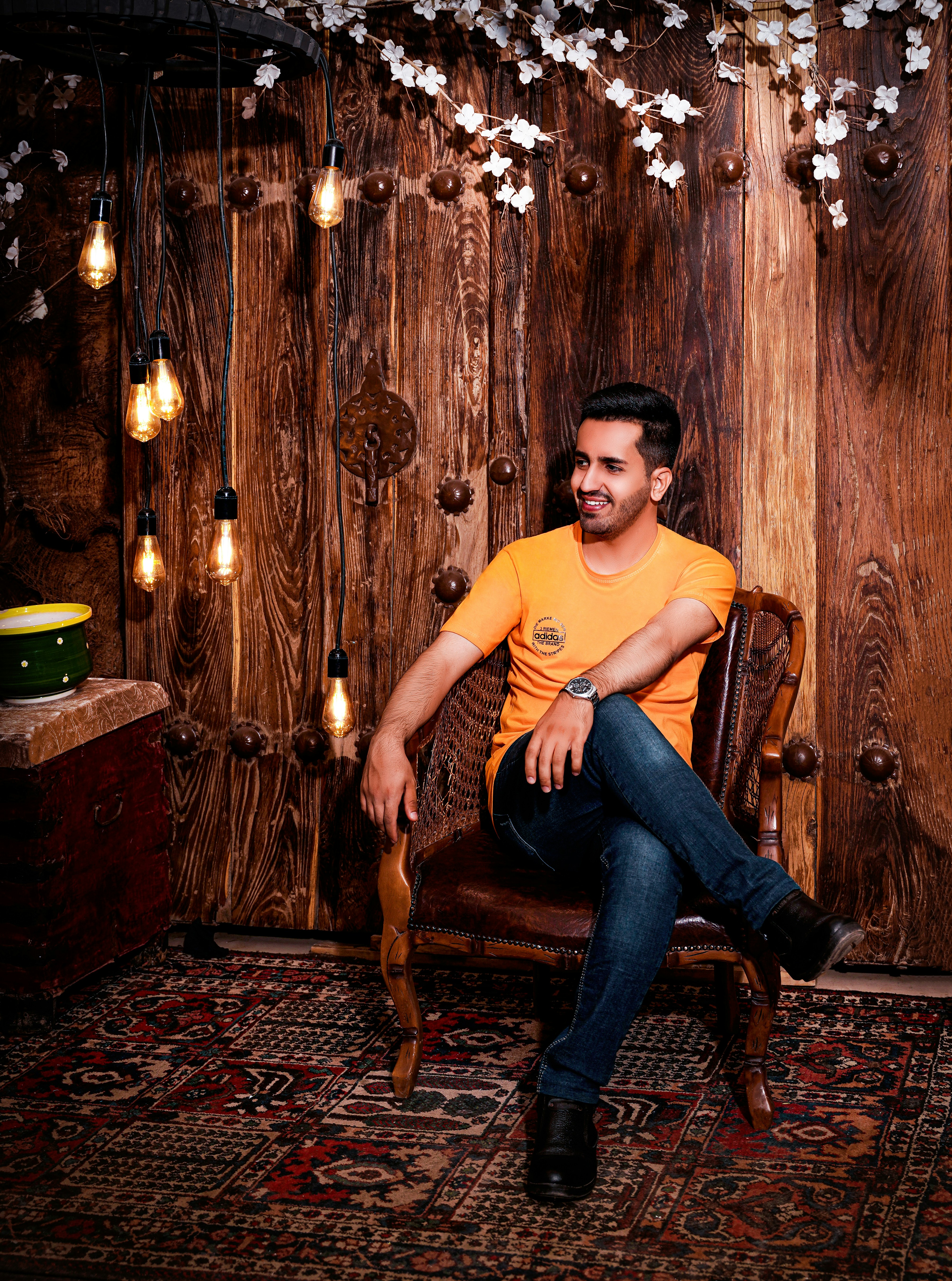 Un homme assis sur une chaise devant un mur en bois photo – Photo L ...