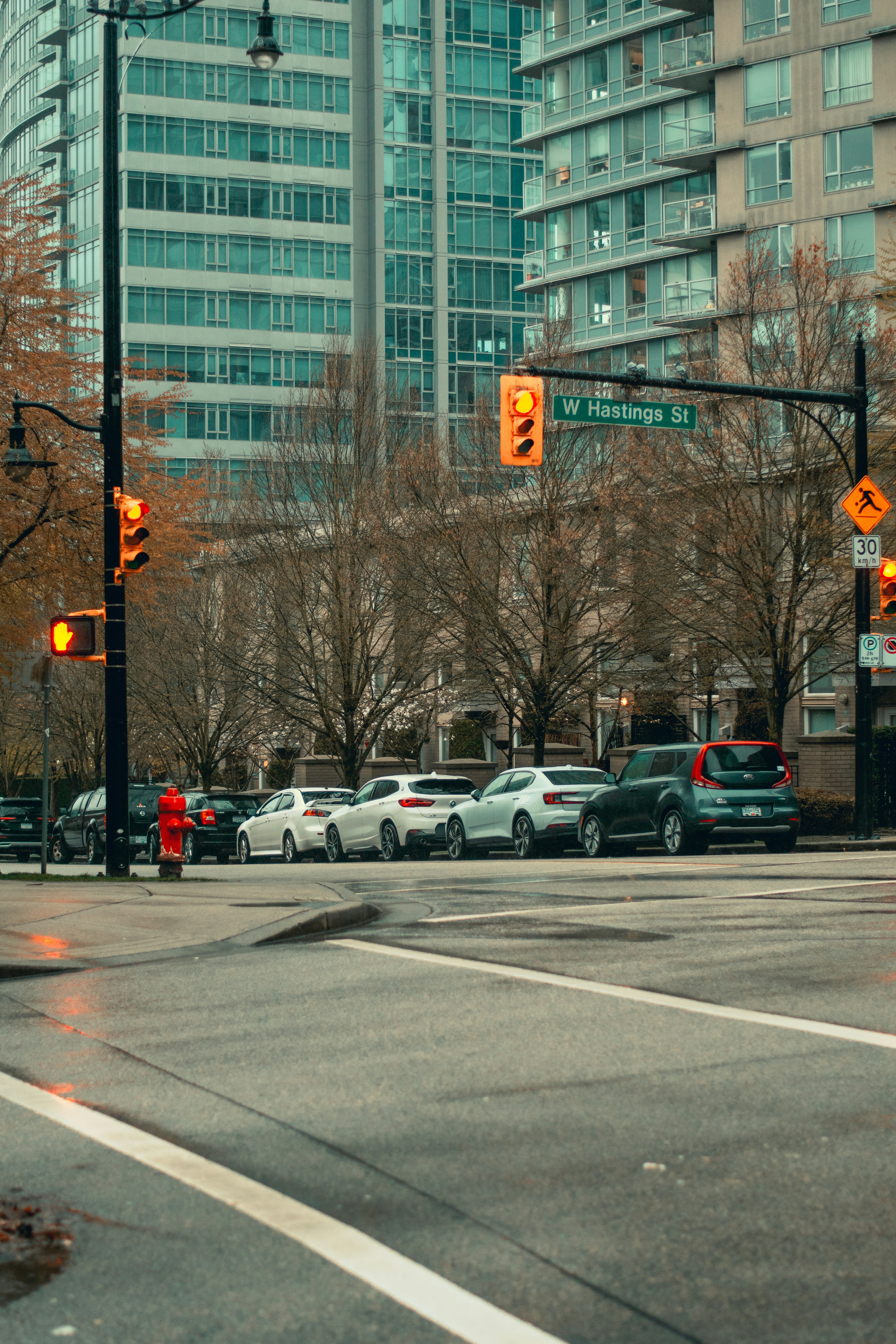 An Intersection in Vancouver. | a city street filled with lots of traffic next to tall buildings