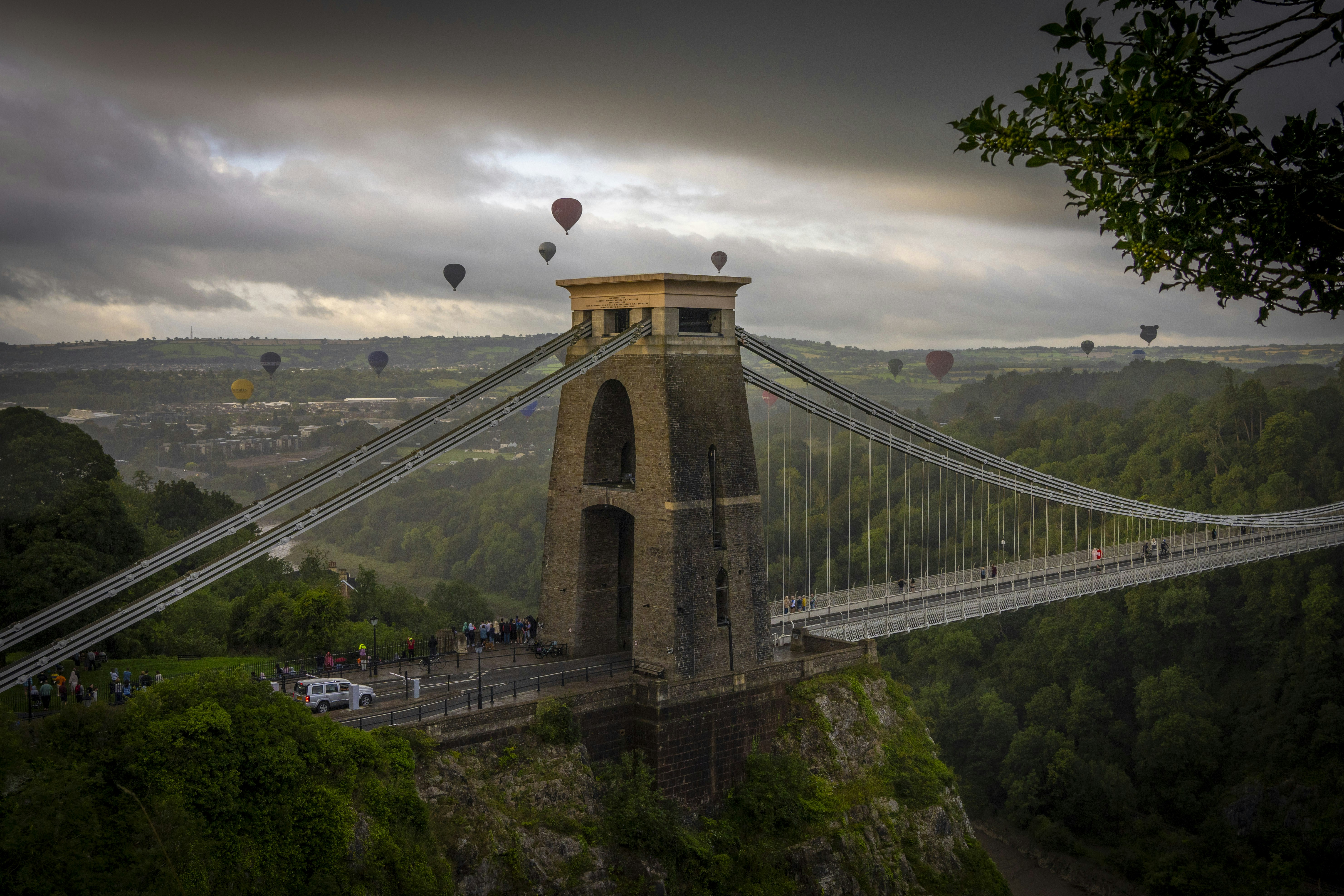 A bridge with hot air balloons flying over it photo – Free Clifton ...