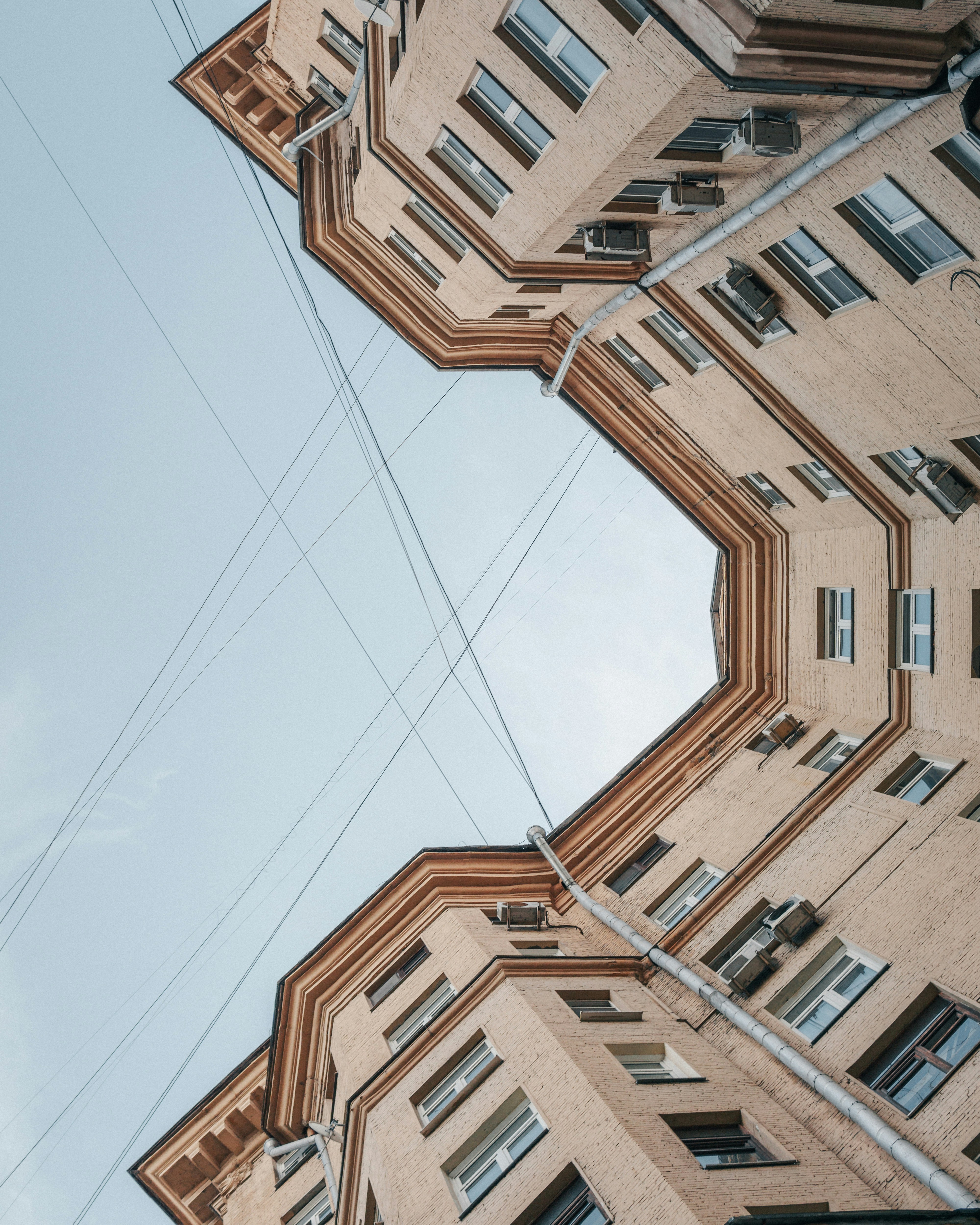 Angular Skyline: Tilted Brick Corner Framed by Wires