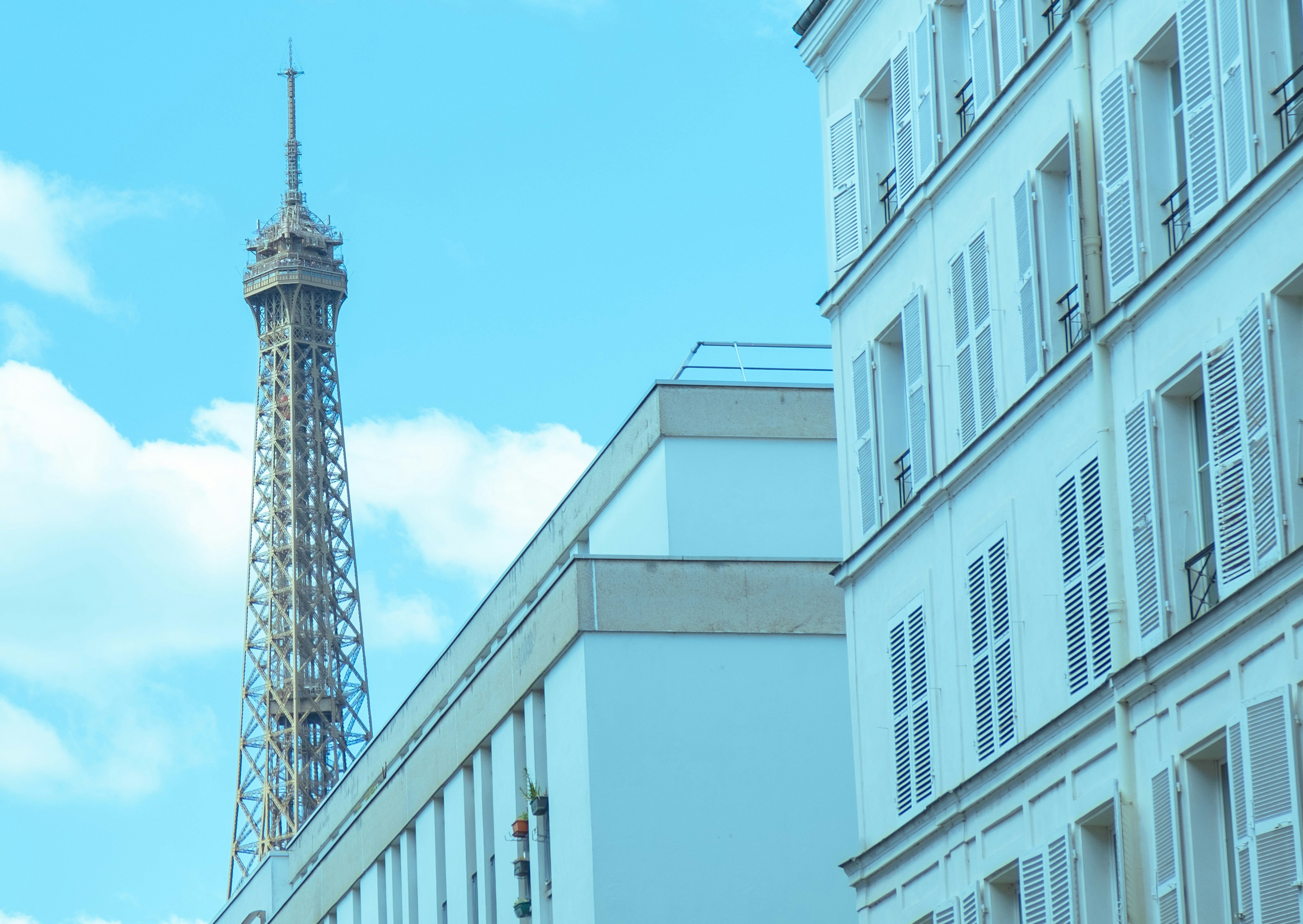 Eiffel Tower Framed by Modern Parisian Facades under a Crisp Blue Sky
