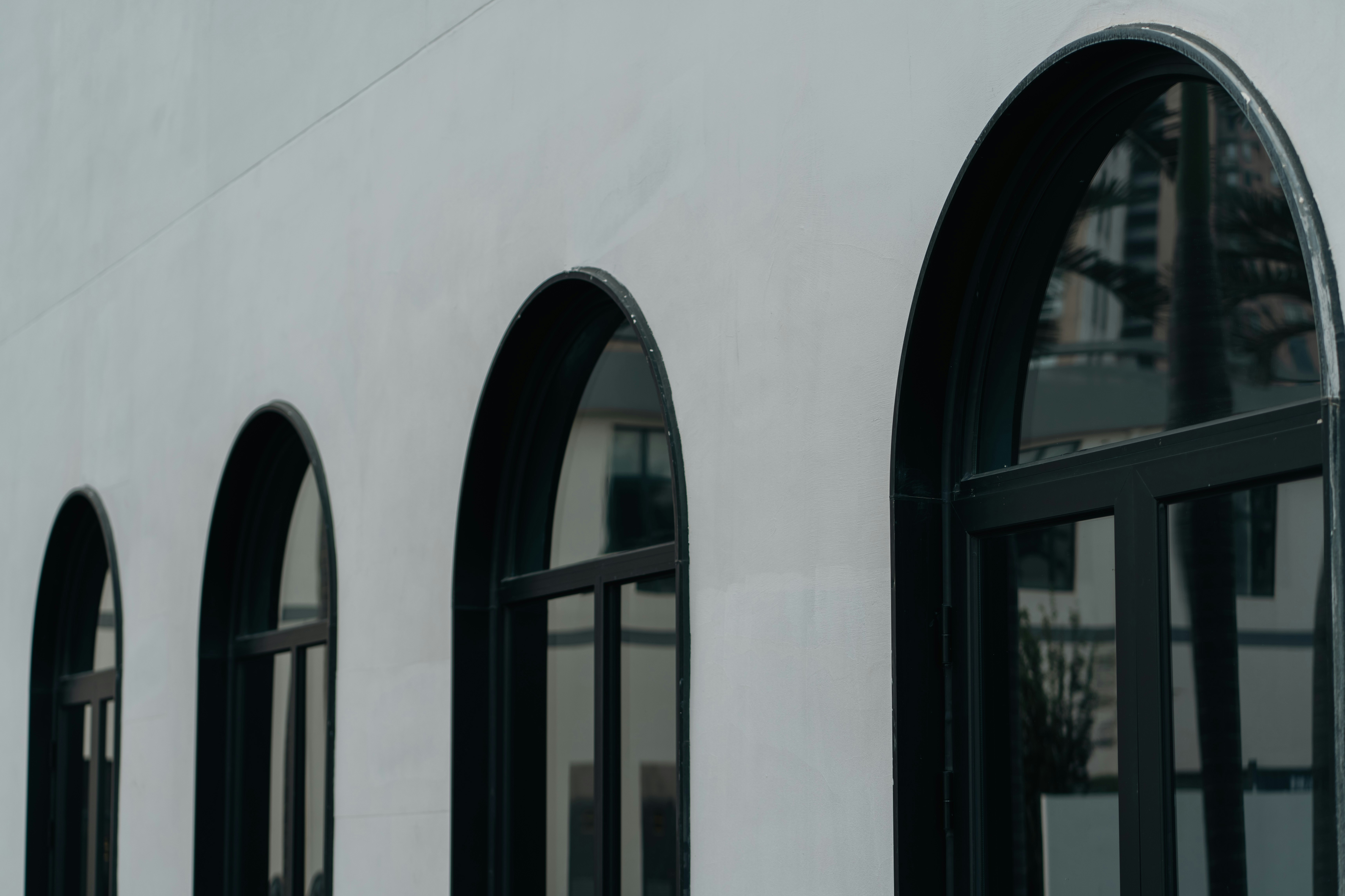 Whispers of Architecture: Dark Arches Against a Pale, Curved Facade