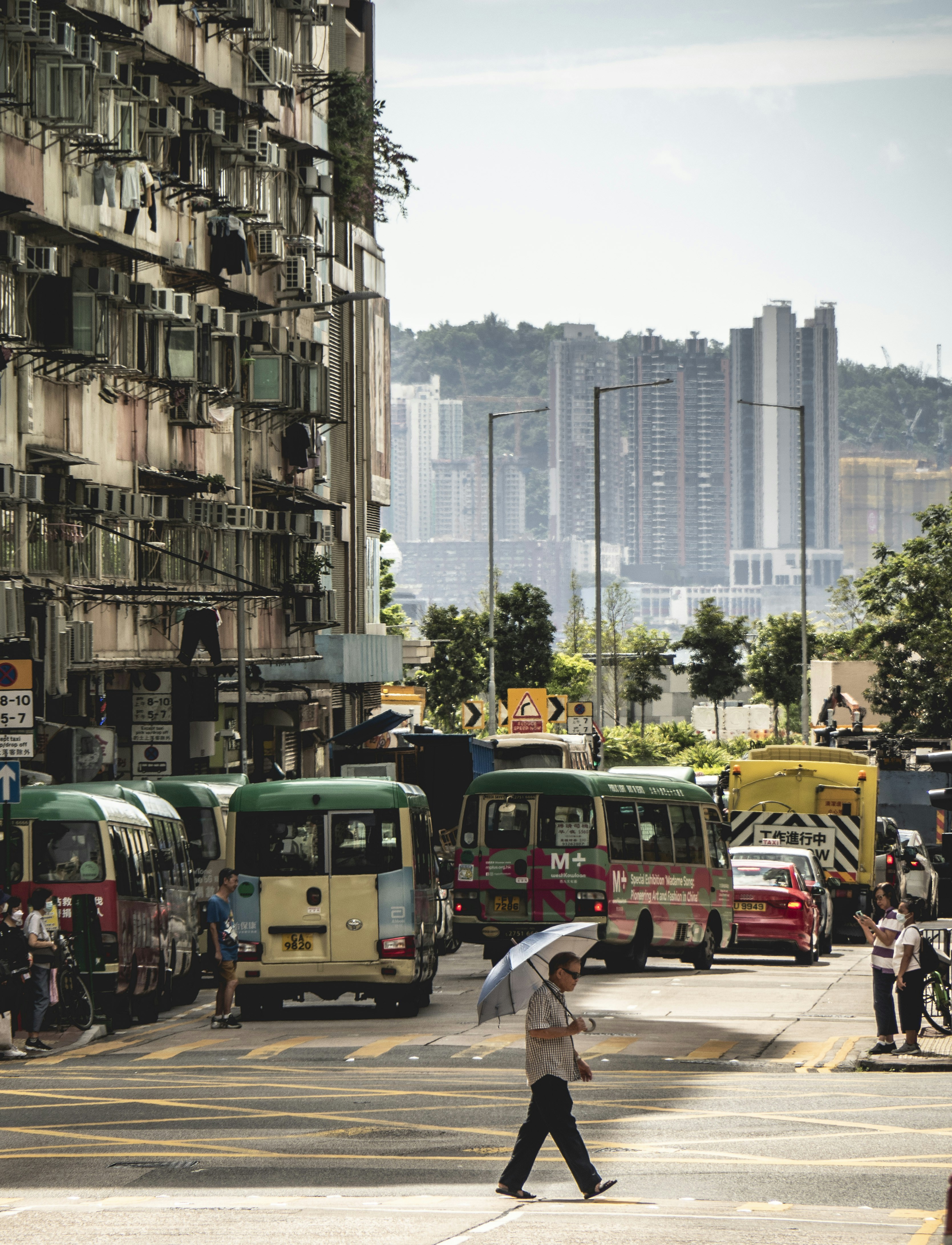 A man walking across a street holding an umbrella photo – Free Kowloon ...