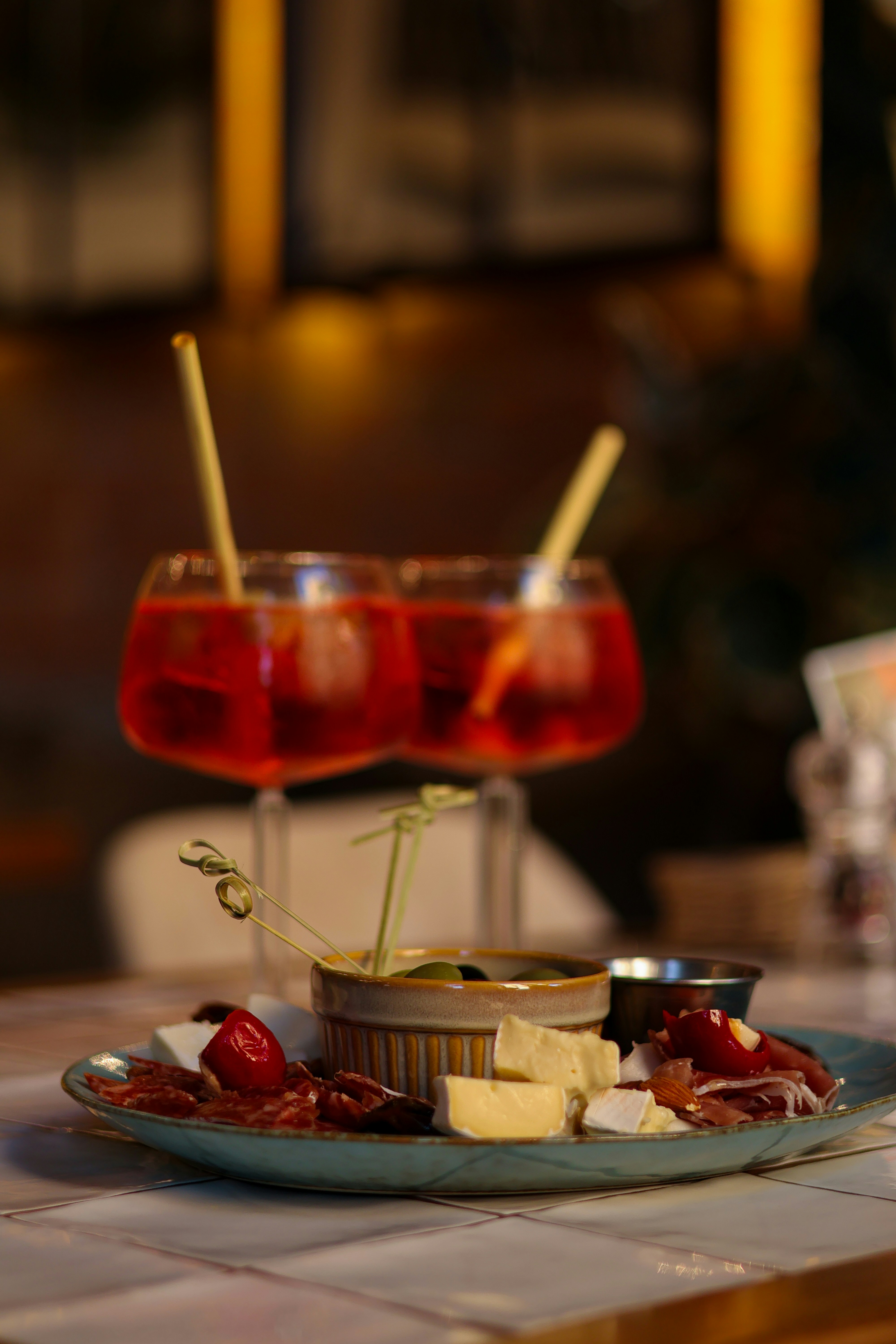 Crimson Aperitifs: A Duo of Glasses Over a Charcuterie Plate