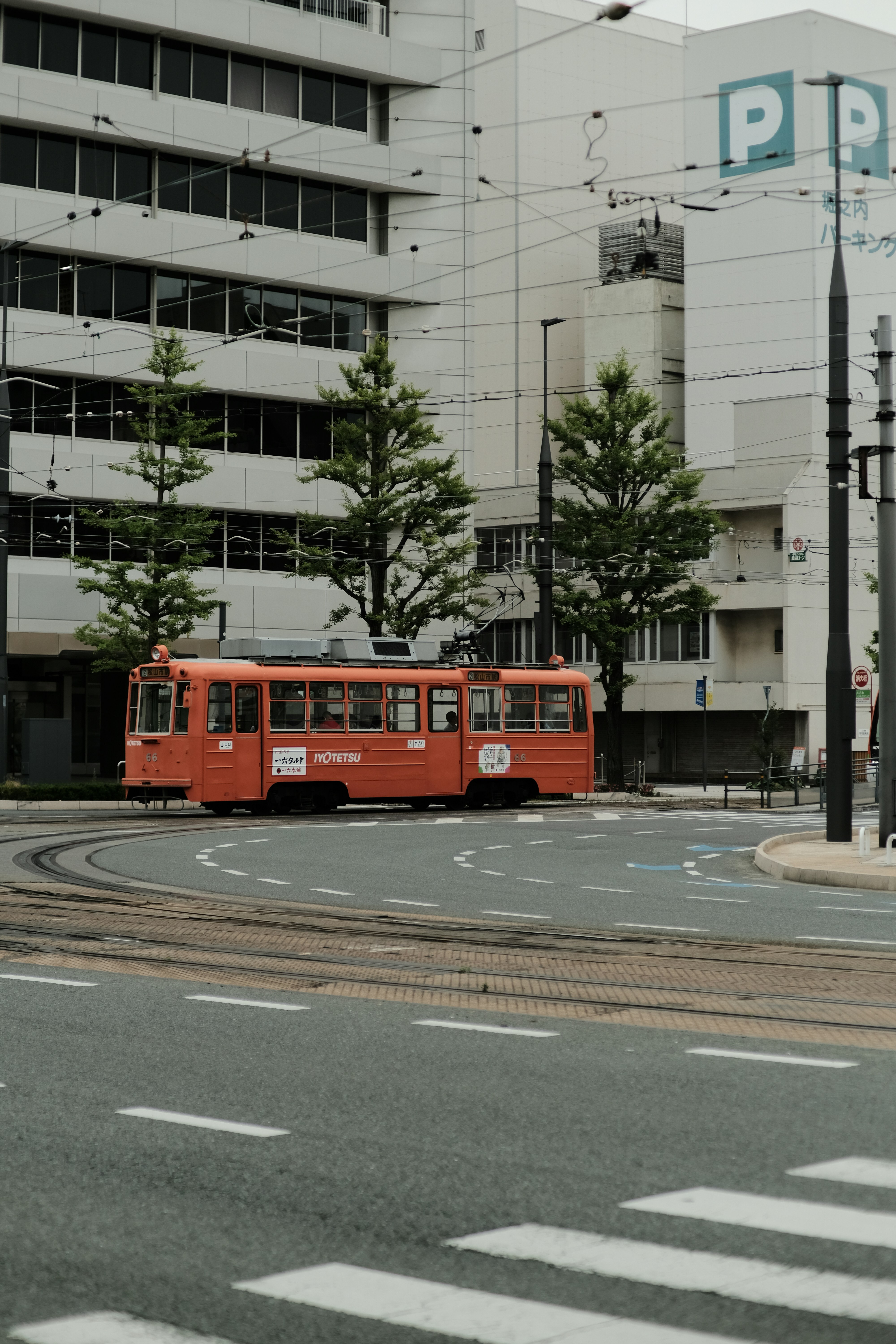 A red bus driving down a street next to tall buildings photo – Free ...