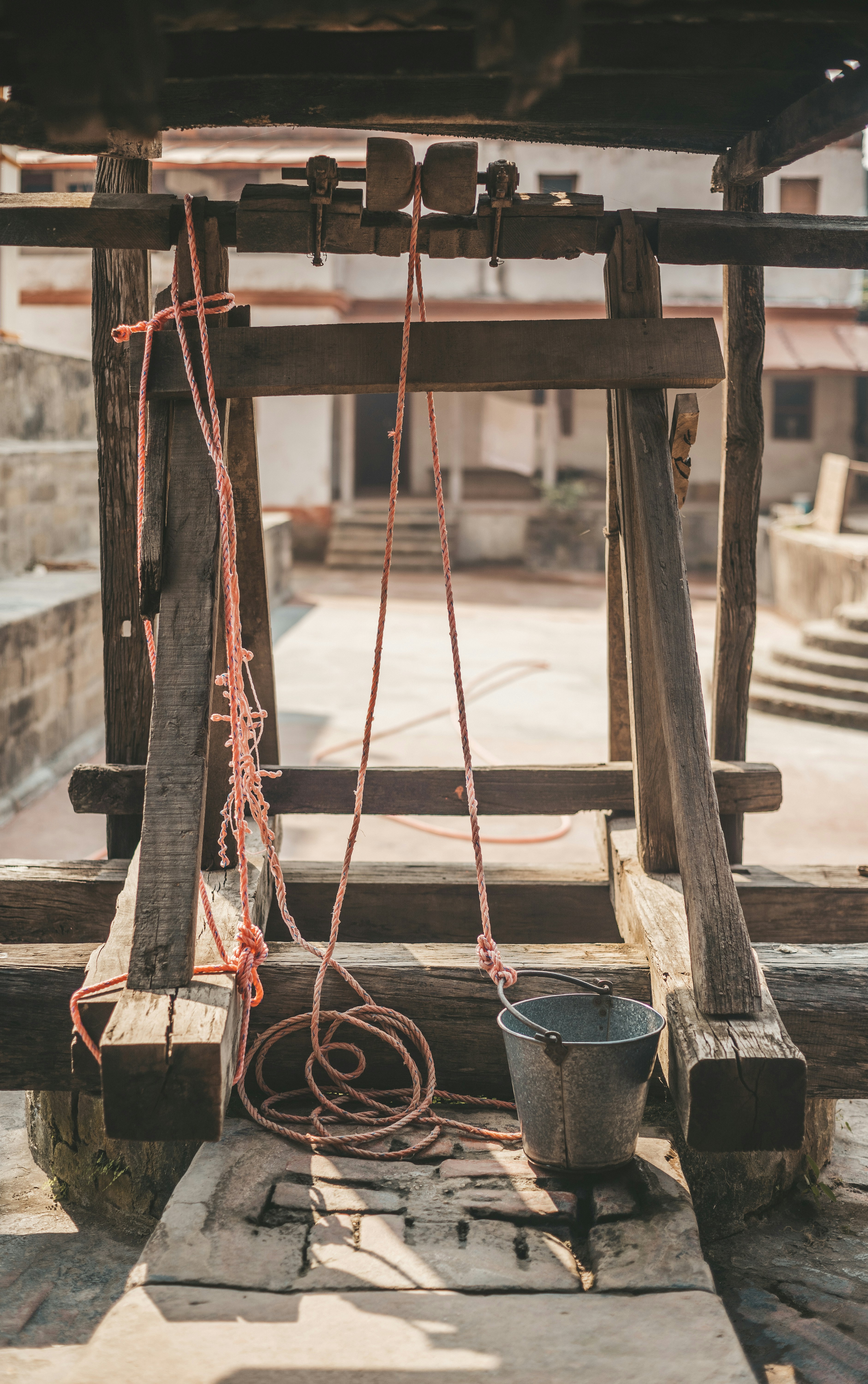 A wooden structure with ropes and buckets hanging from it photo – Free ...