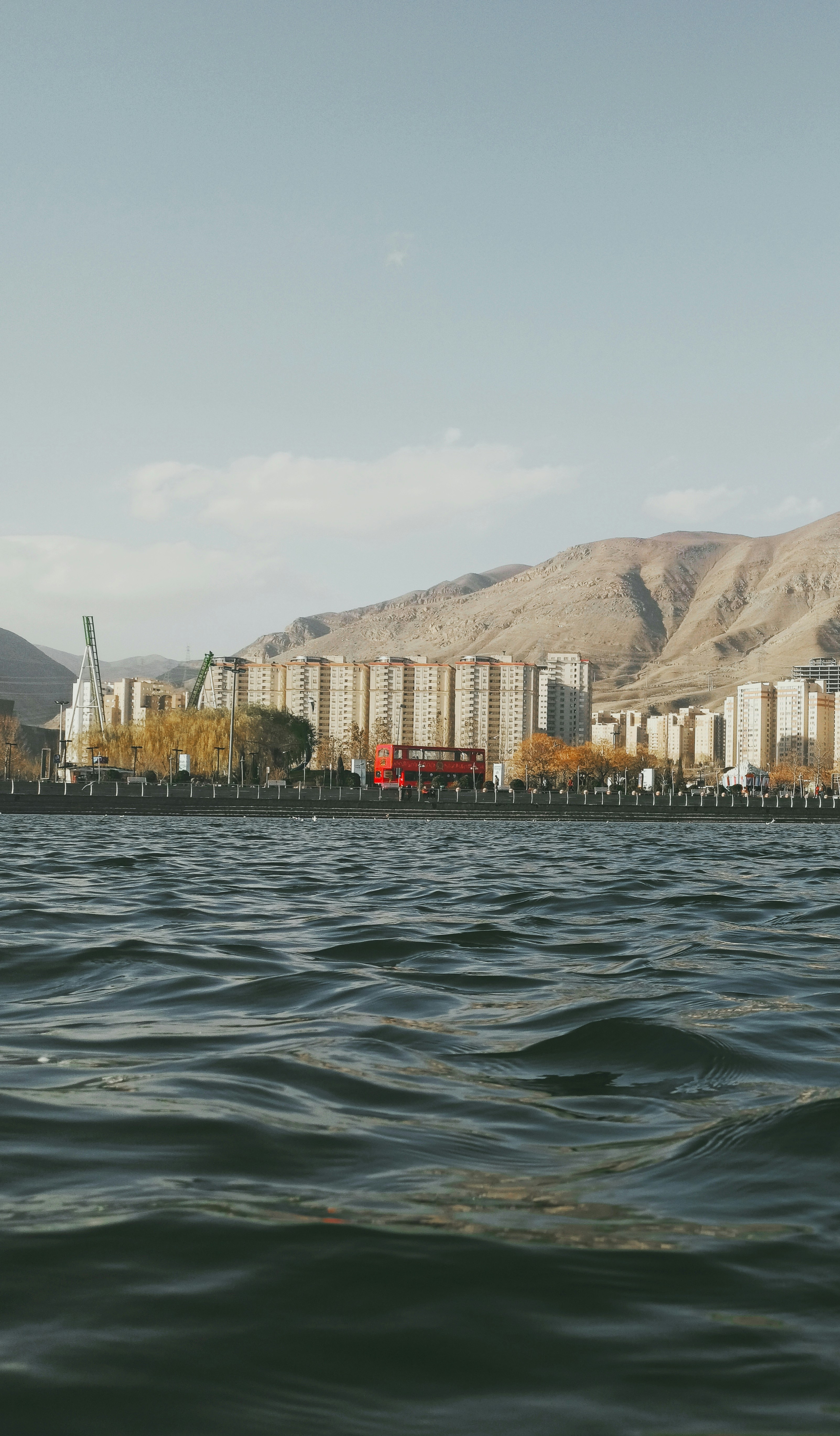 Red Bus at the Waterfront: A City Framed by Arid Mountains